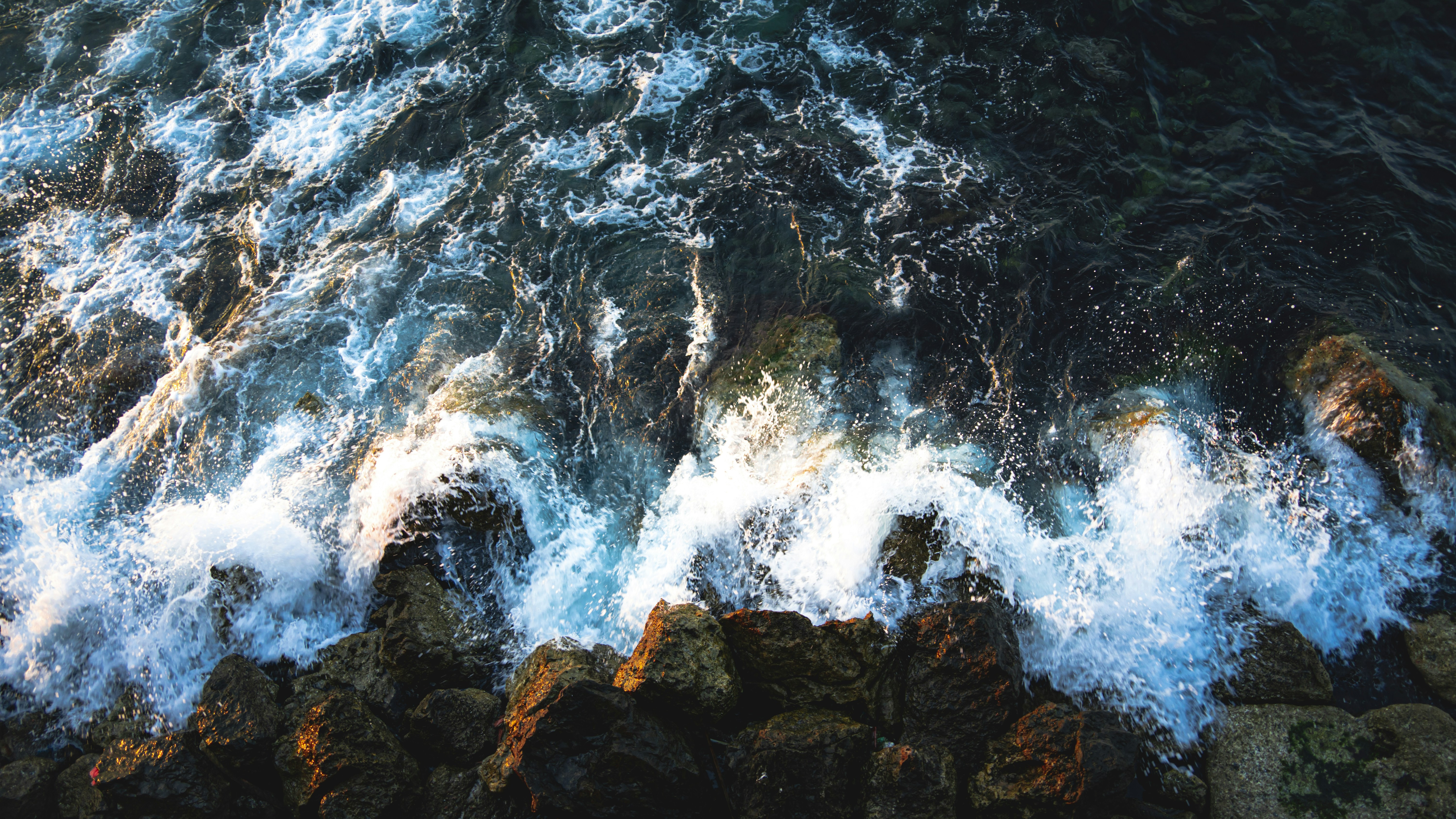 Olas rompiendo contra la costa rocosa con el rocío del mar foto ...