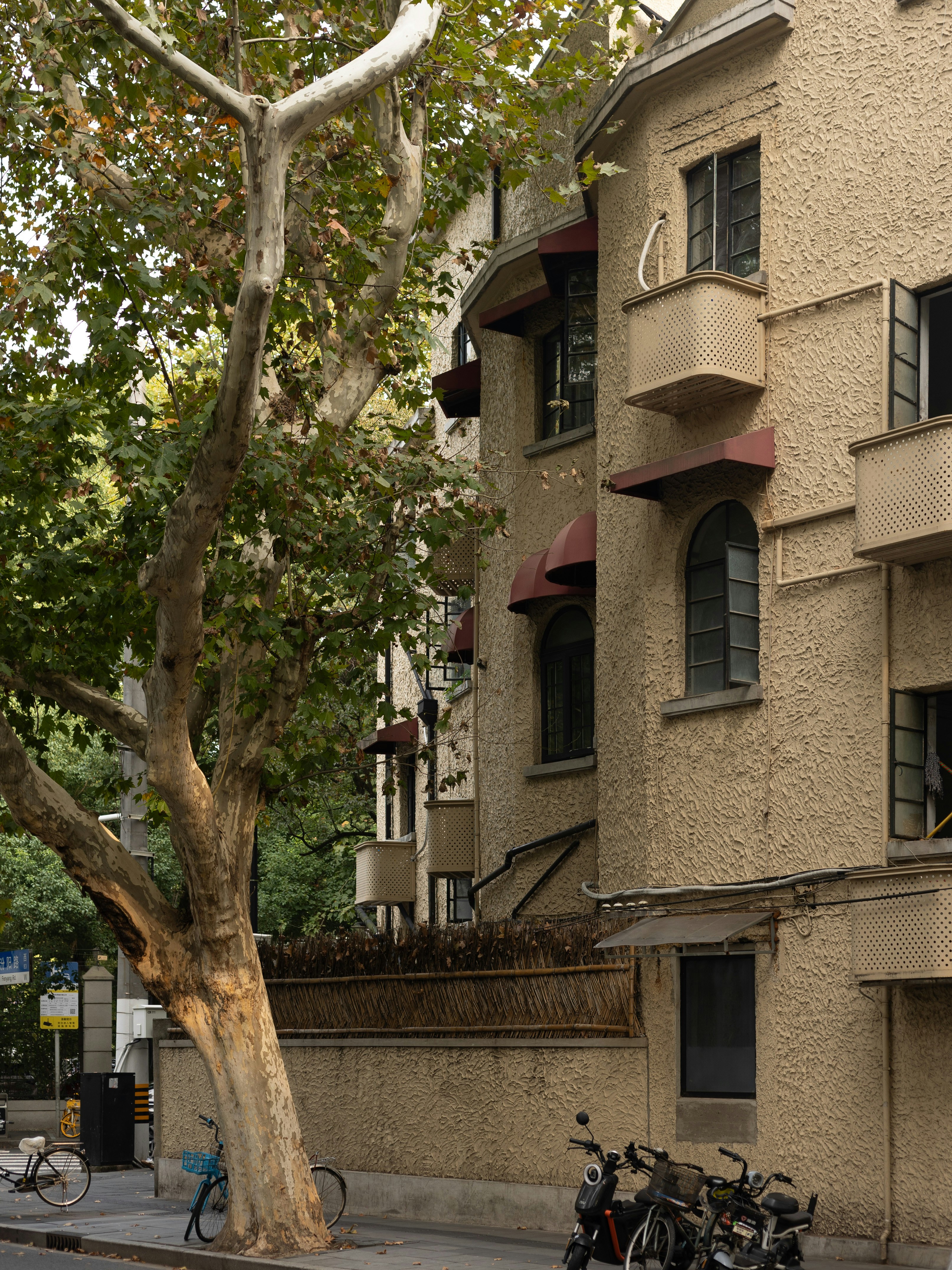 Apartment buildings with trees and parked motorcycles.