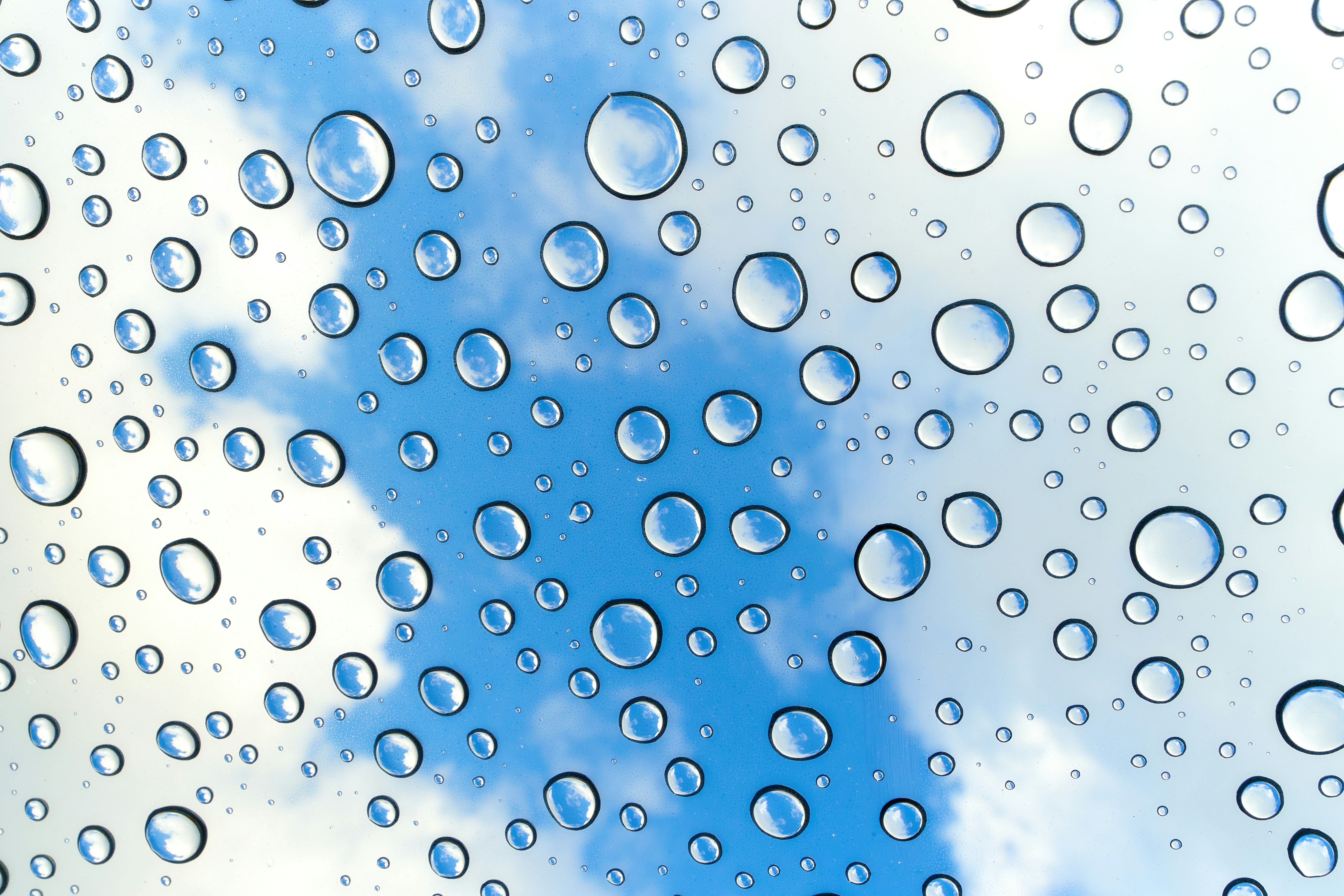 Water droplets on glass with blue sky background