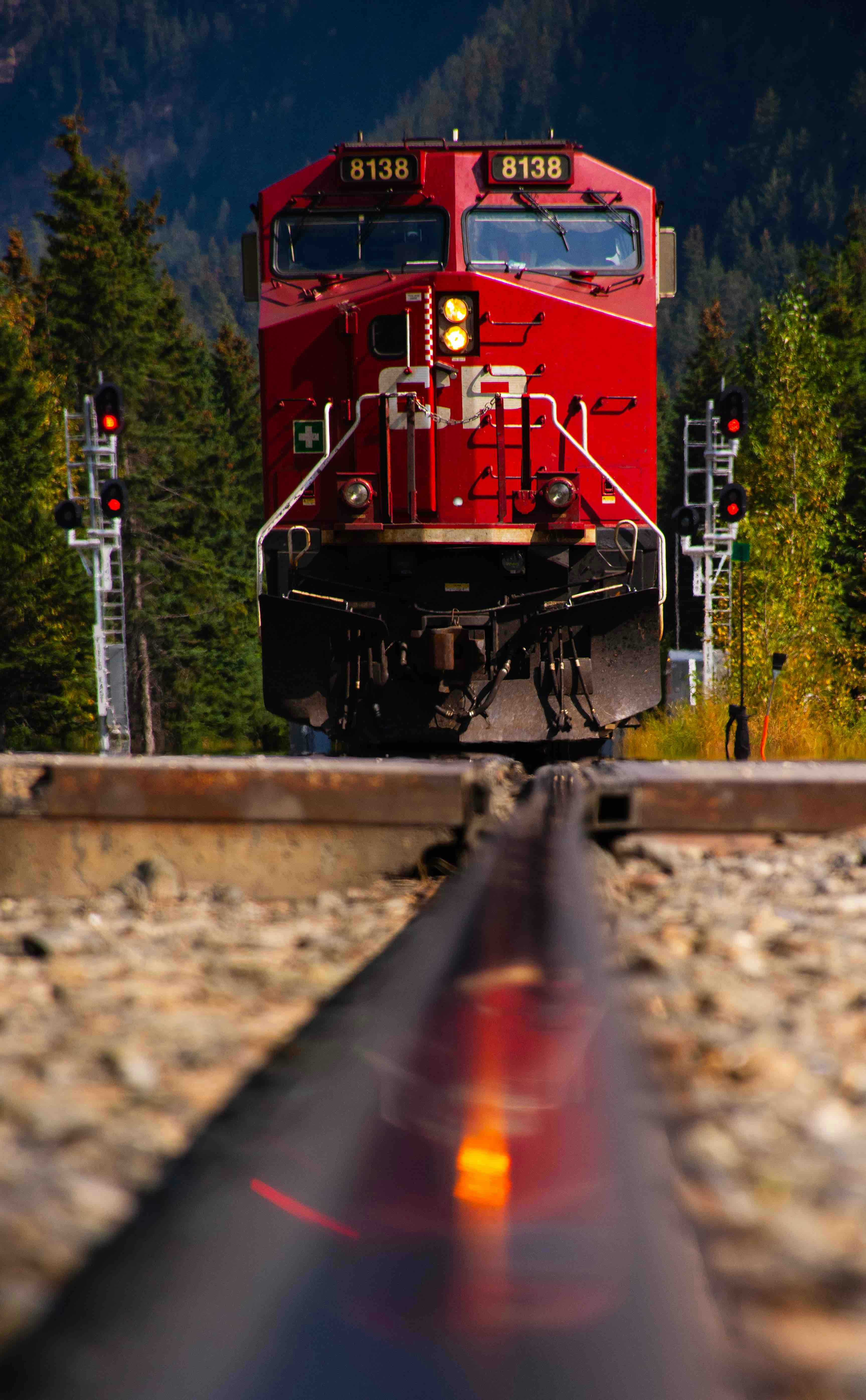A red train approaches on a railway track. photo – Free Travel Image on ...