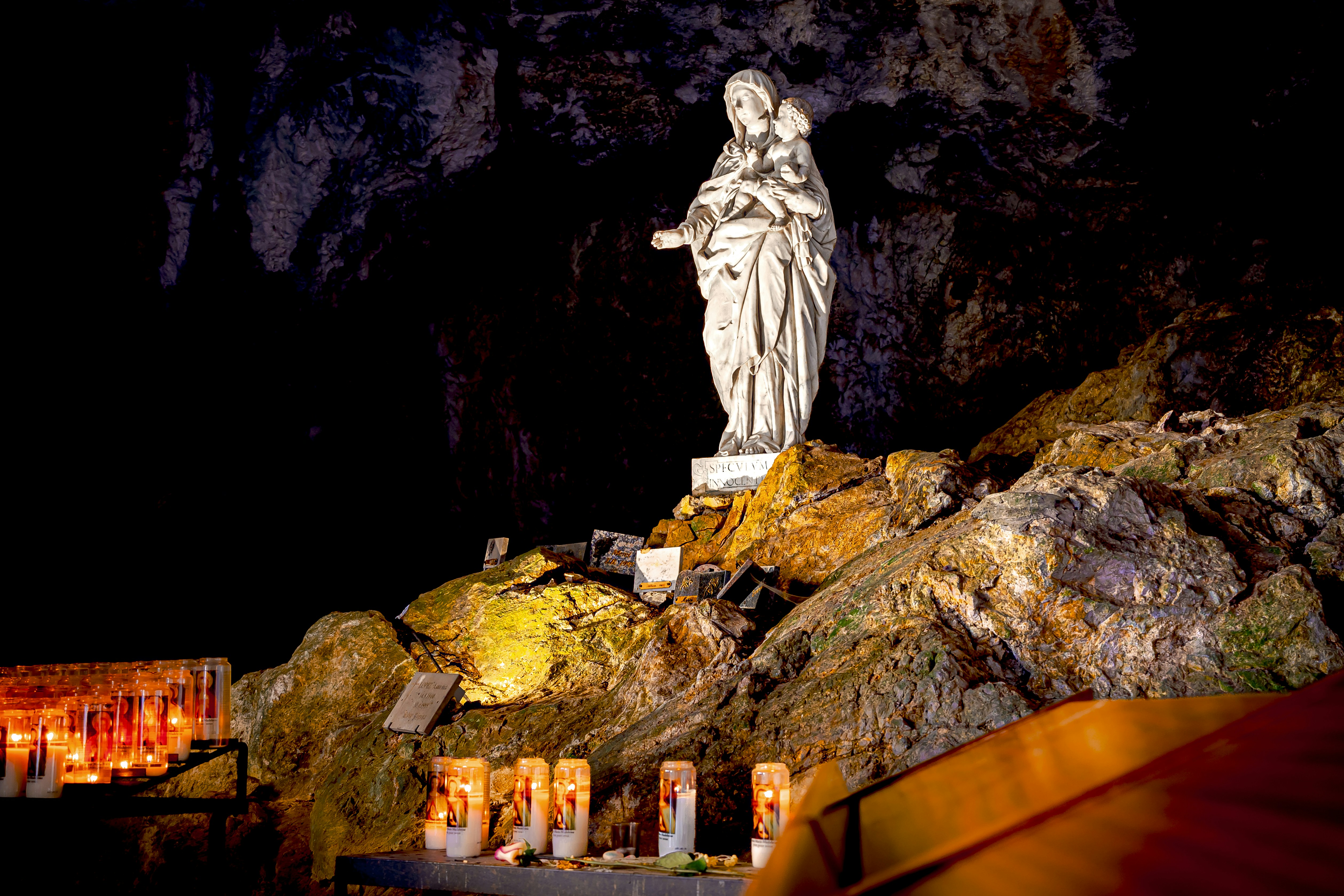 Candled Cavern Shrine: The Virgin Mary Statue Emerges from Rock