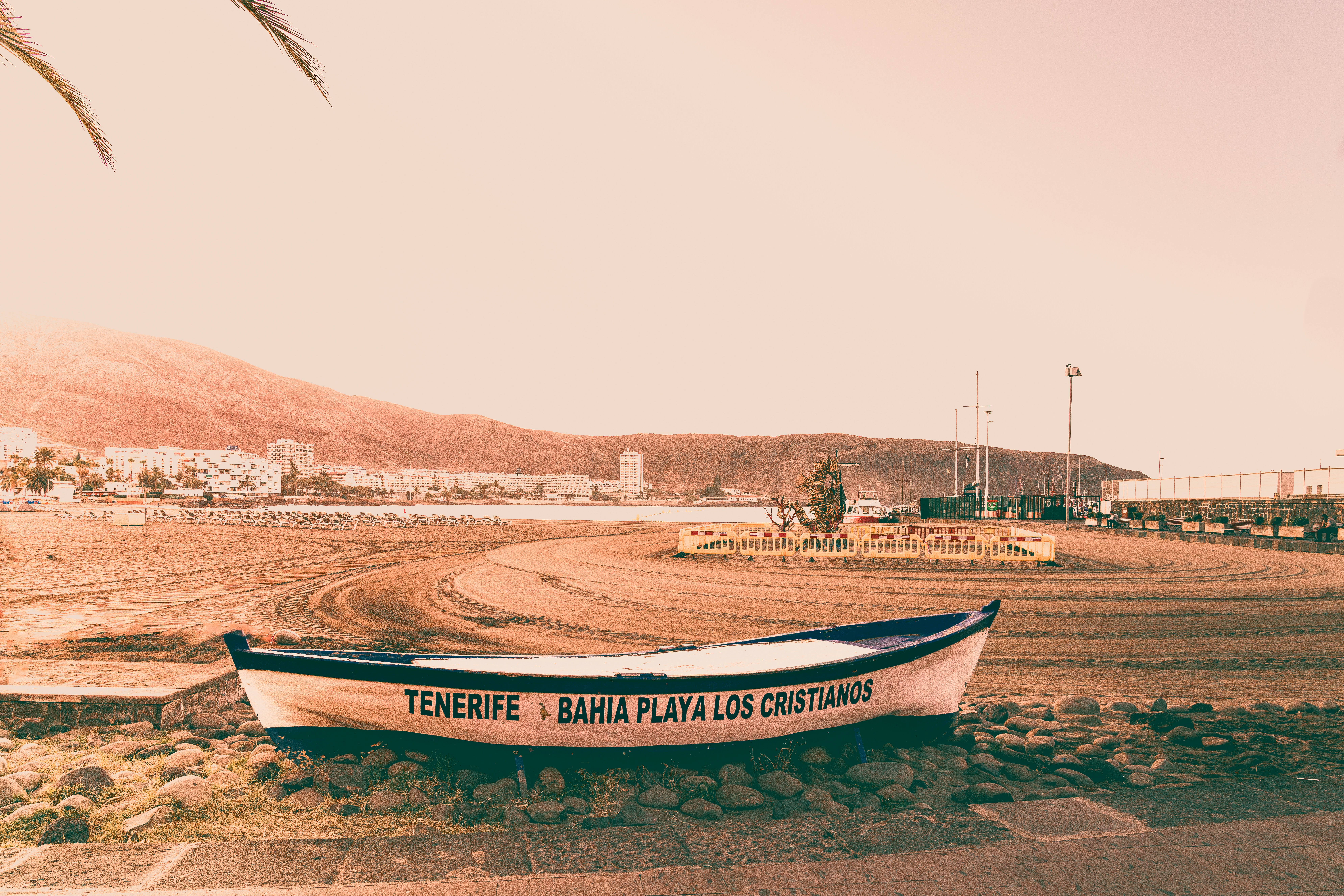 Pequeño bote en una playa de arena con montañas distantes foto – Imagen ...