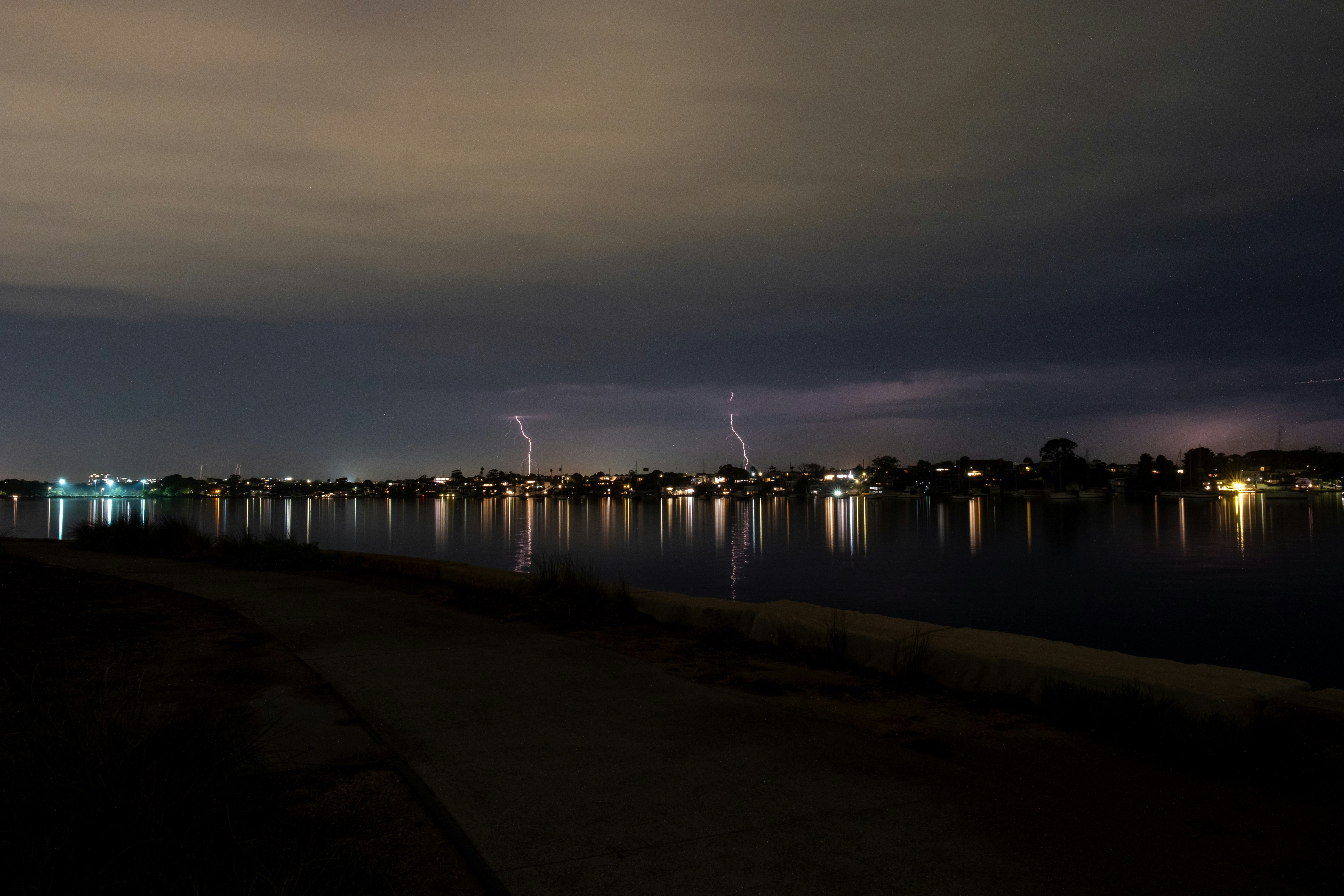 Lightning Threads Over a Glassy Lakefront at Midnight