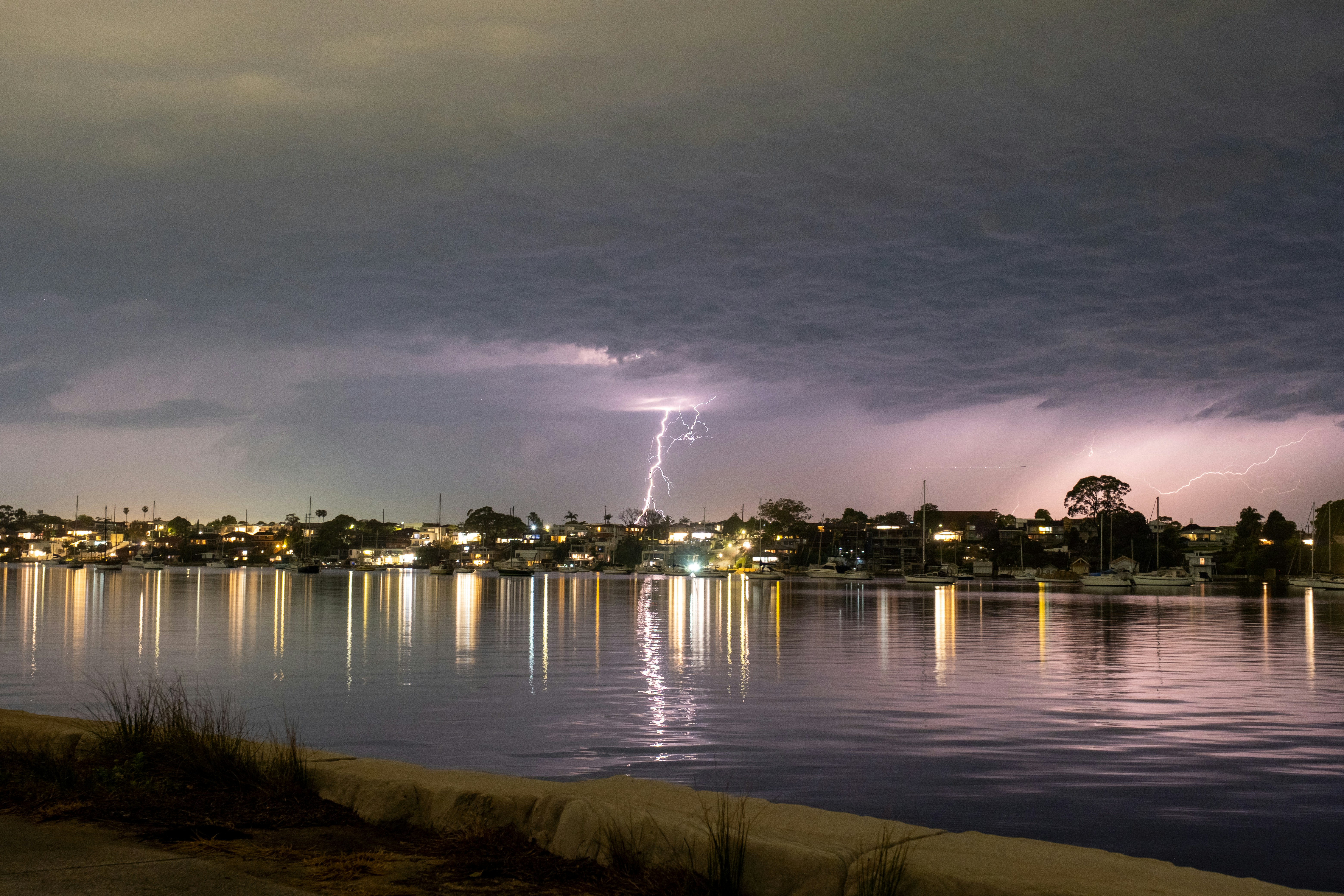 Lightning Forks Over a Quiet Lakeside Town at Night