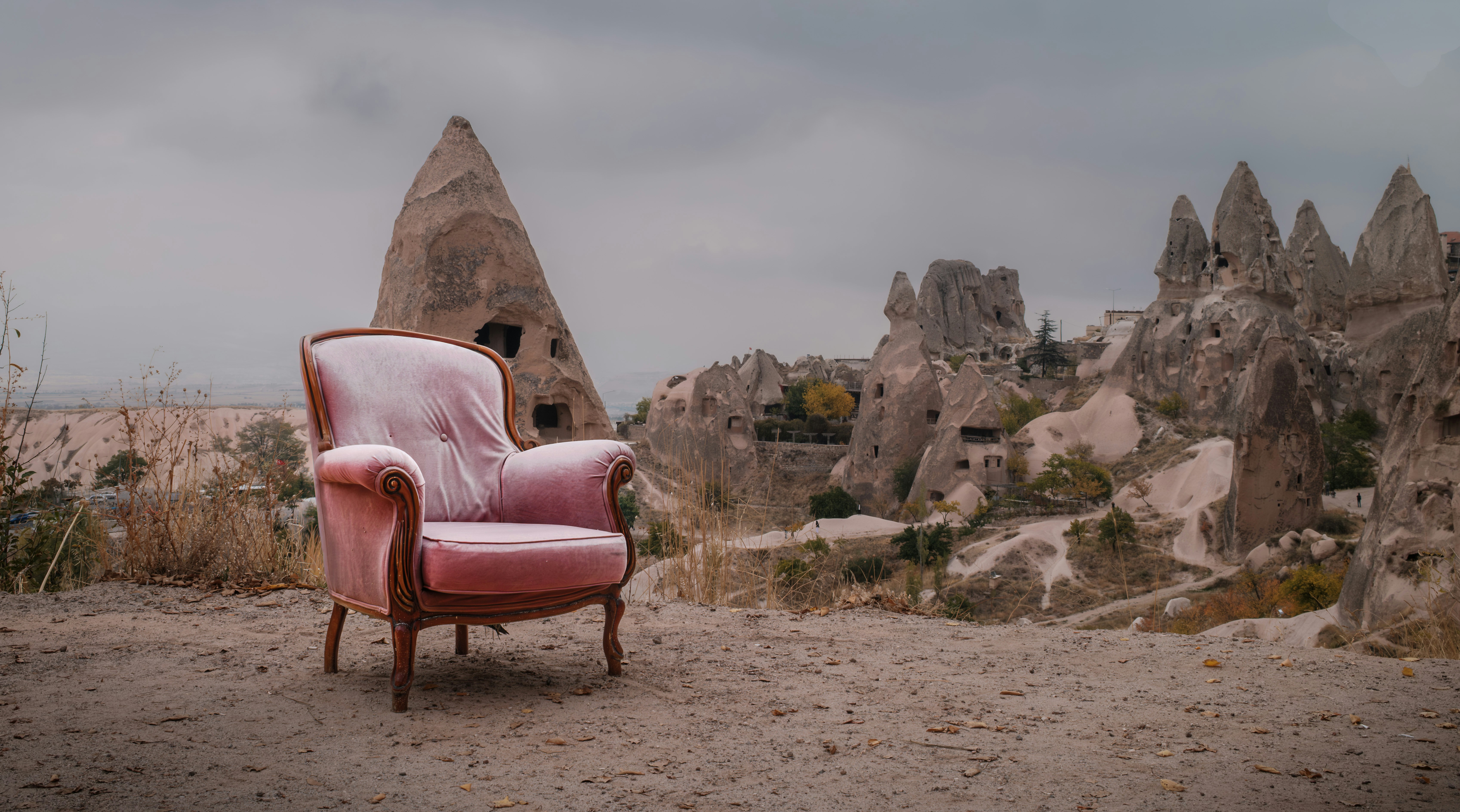 A pink armchair sits in a rocky, desolate landscape. photo – Free ...