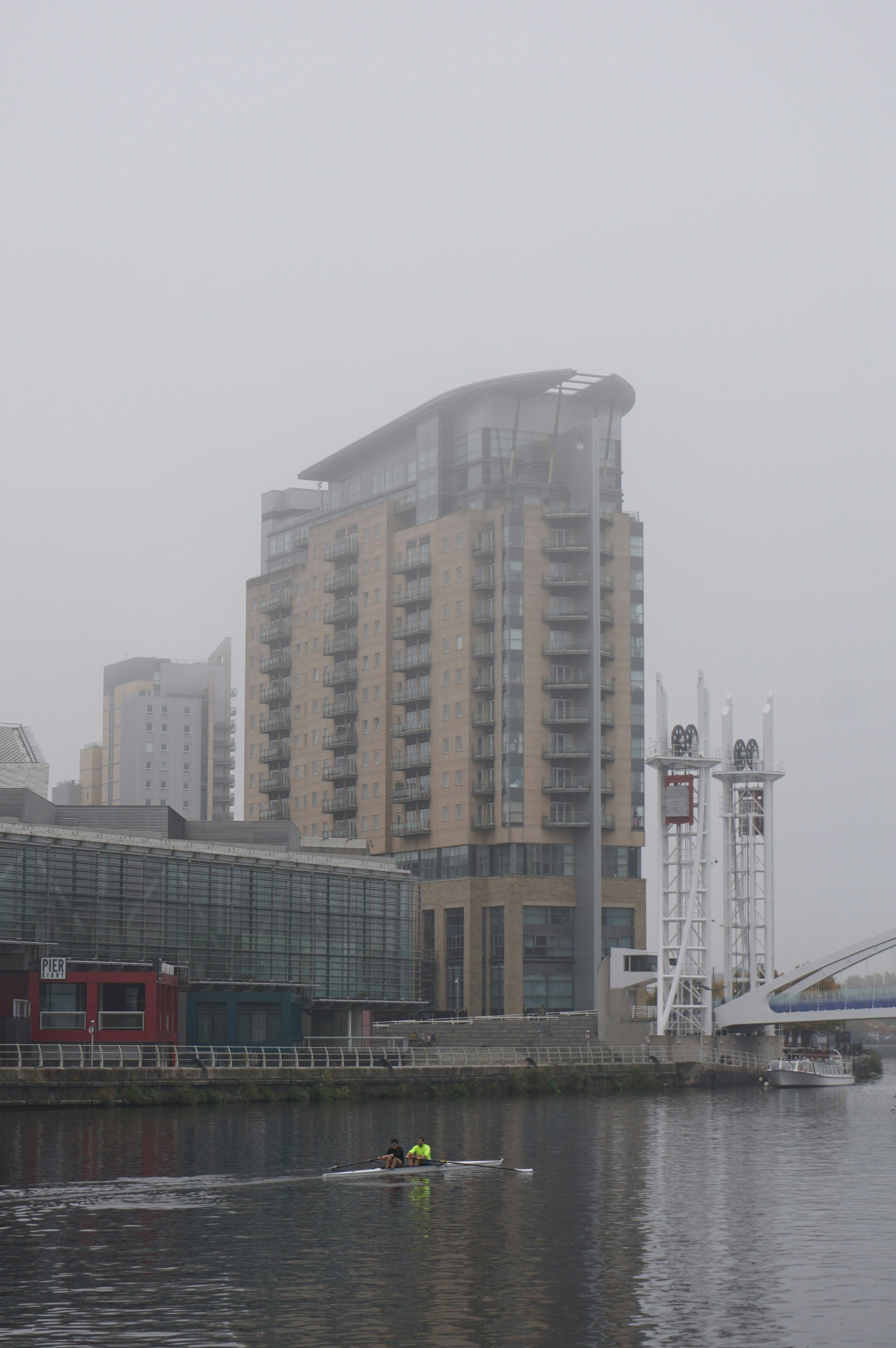 Mist over the Riverside: A Curved-Roof Tower Dominates a Quiet Waterfront