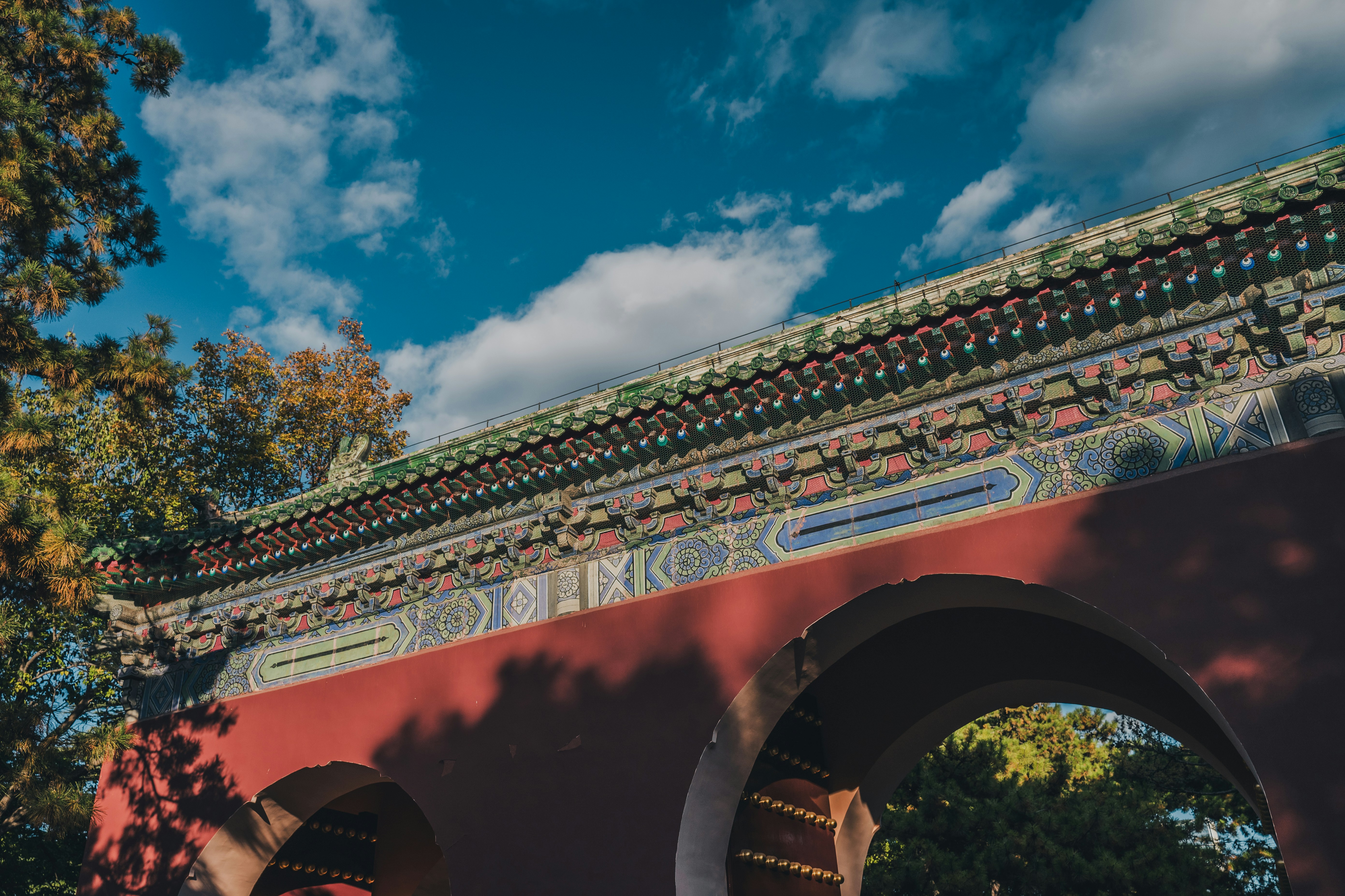 Intricately designed archway adorned with vibrant patterns under a clear blue sky, showcasing traditional architectural beauty.