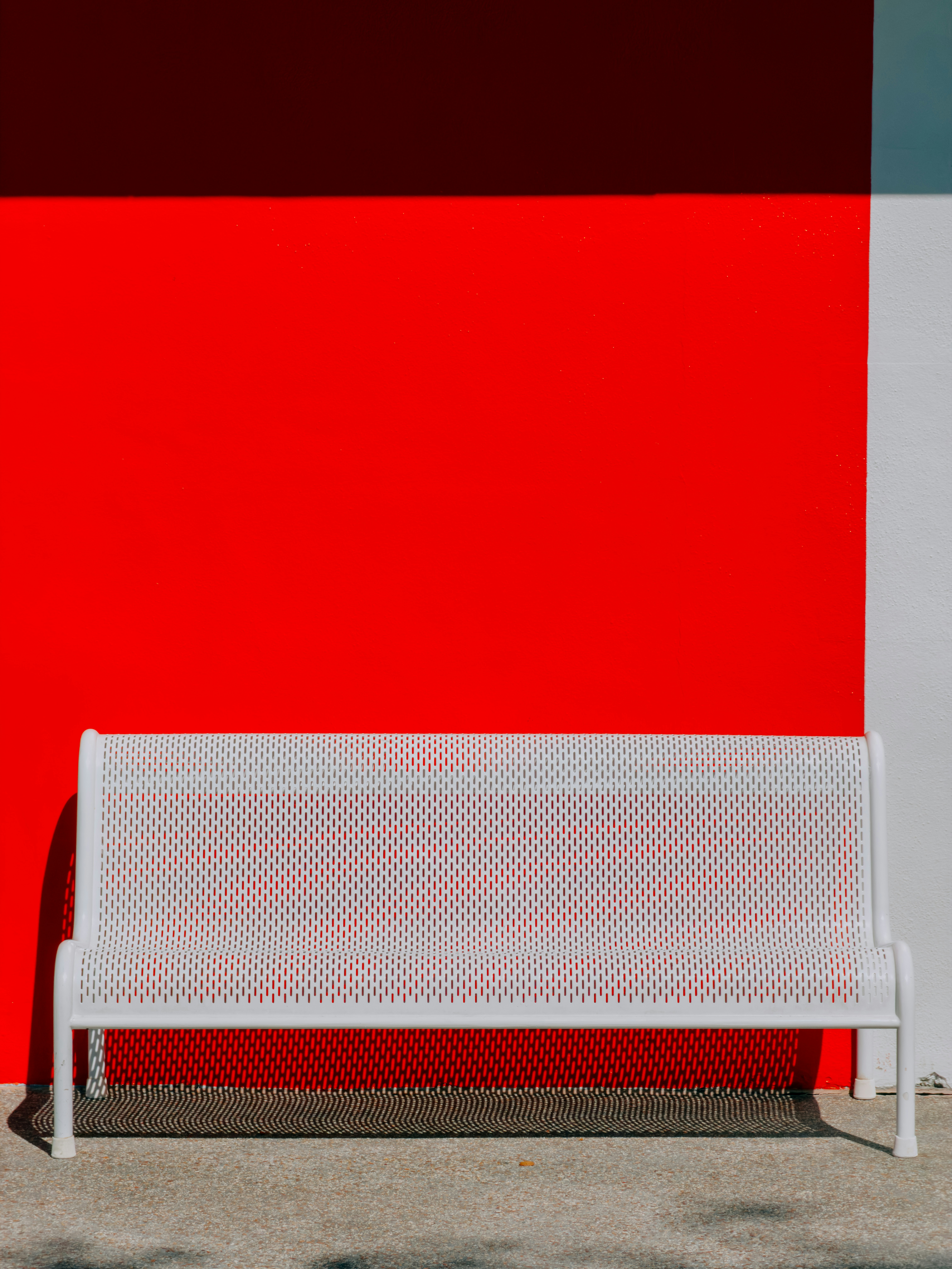 Red-Block Minimalism: White Bench Beneath a Striking Wall