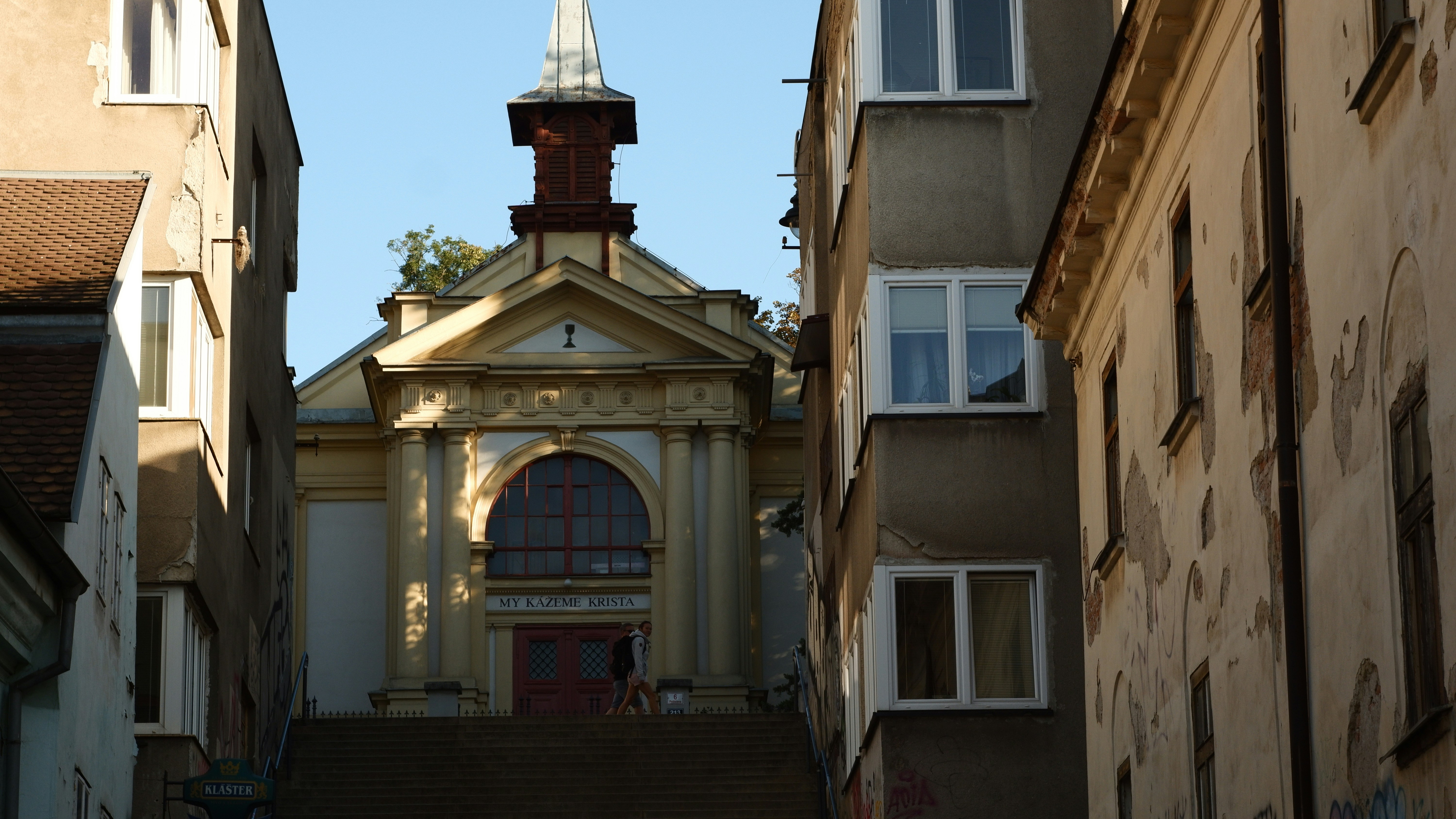 An old building with a steeple between two modern buildings. photo ...