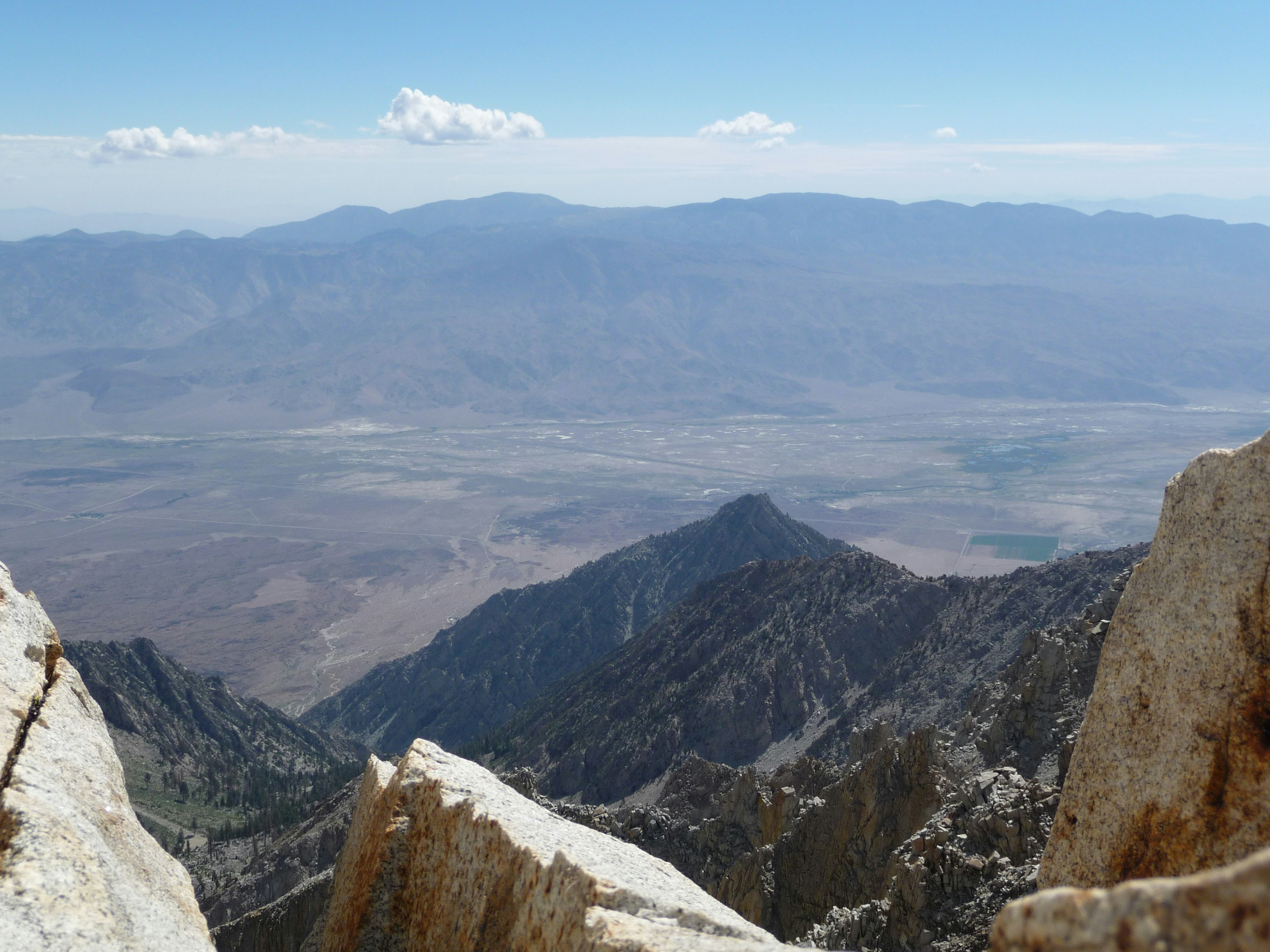 A vast mountain landscape under a clear blue sky.