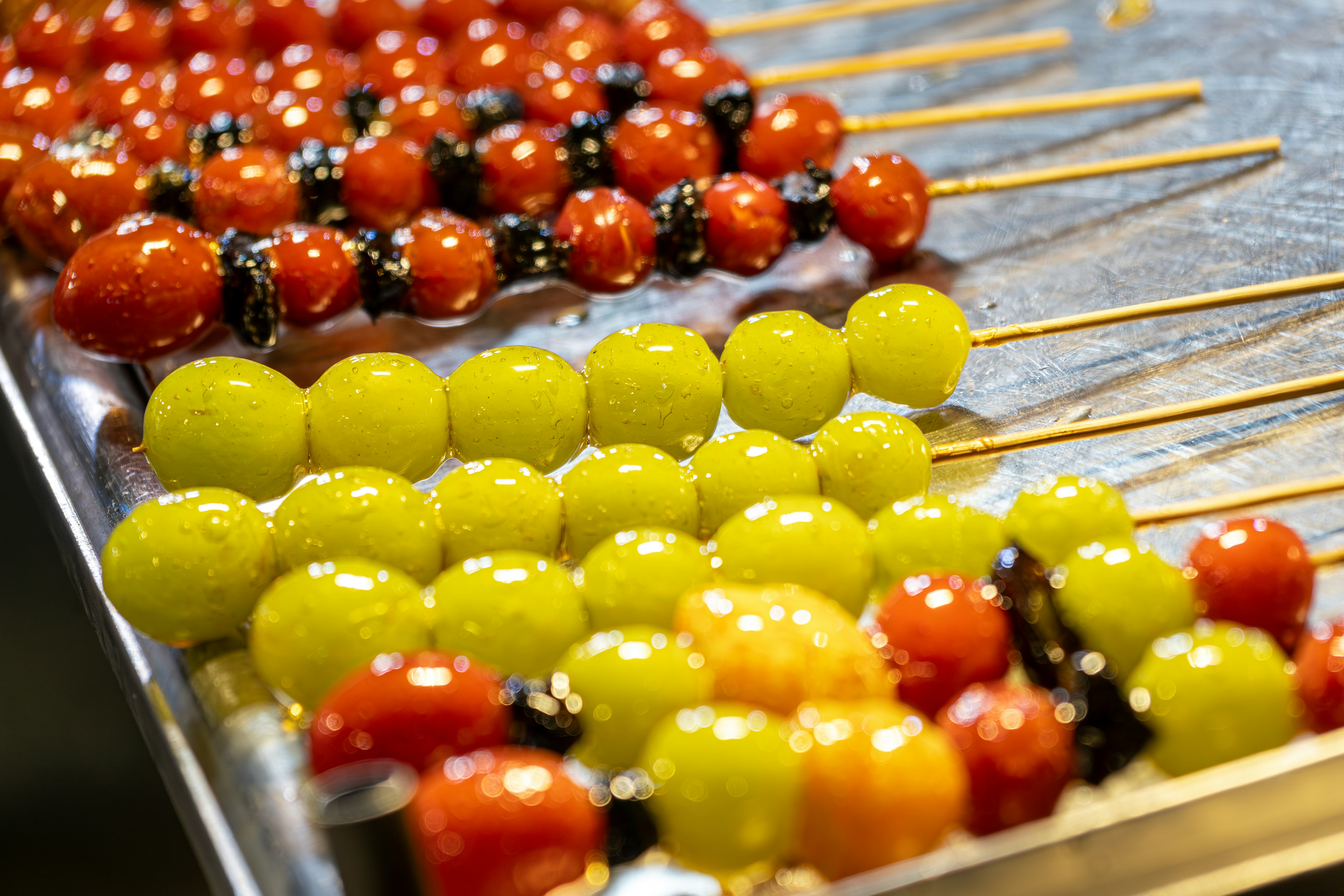 Candy Skewers on a Metal Tray: Vivid Yellow and Ruby Orbs