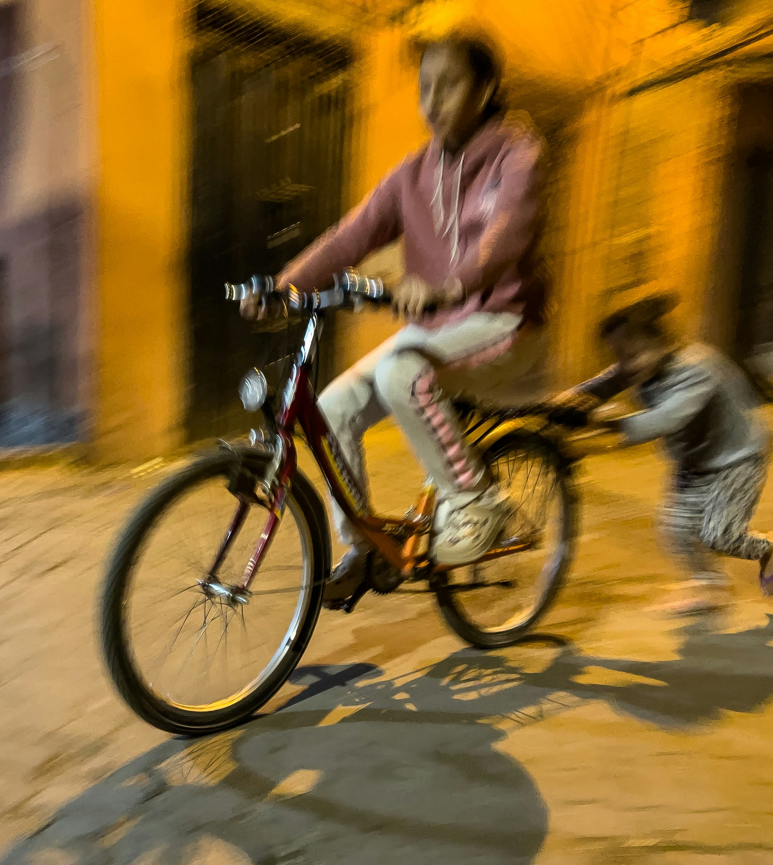 Children riding a bicycle at night