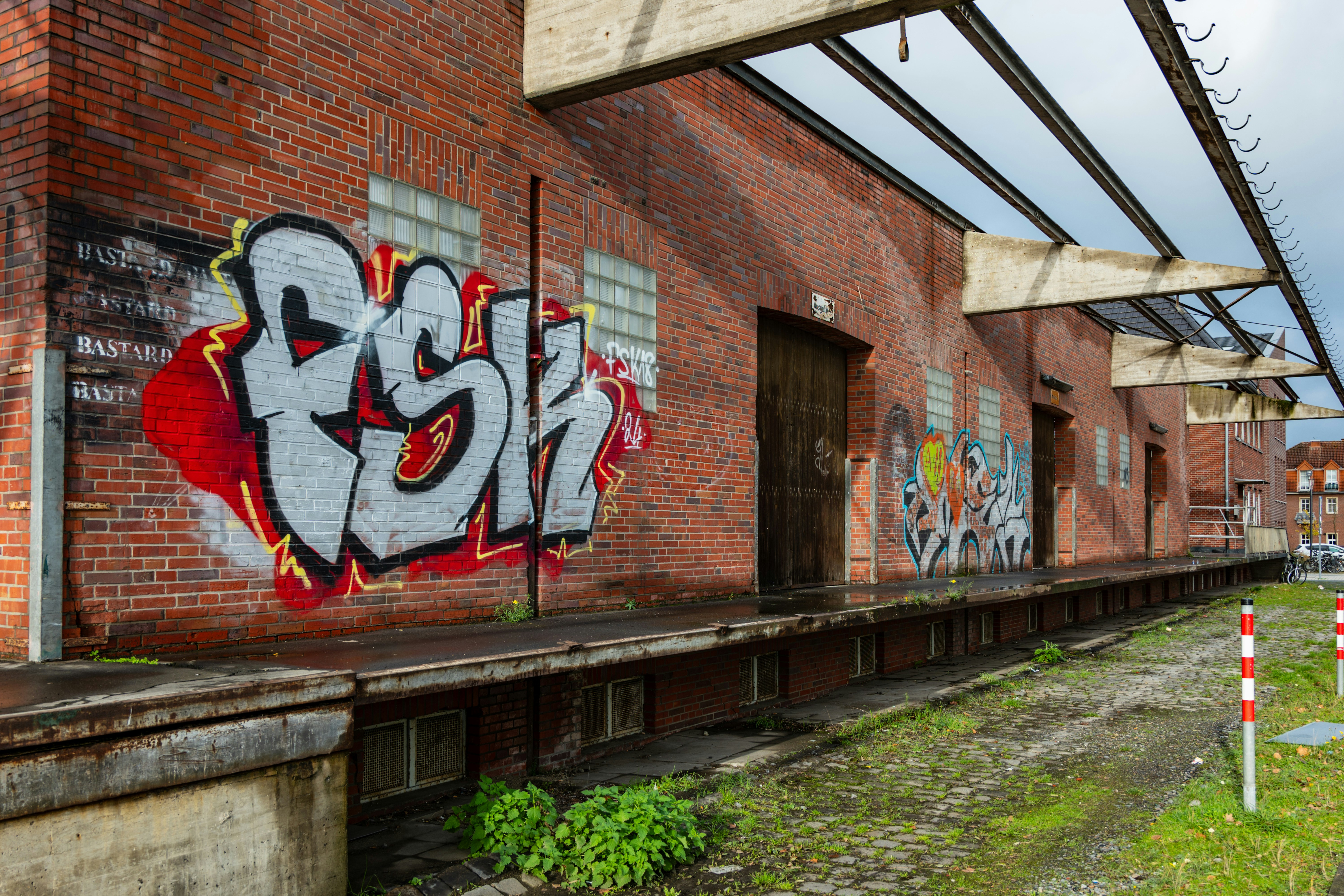 Bold Tag on Red Brick: Graffiti Framing an Empty Industrial Platform