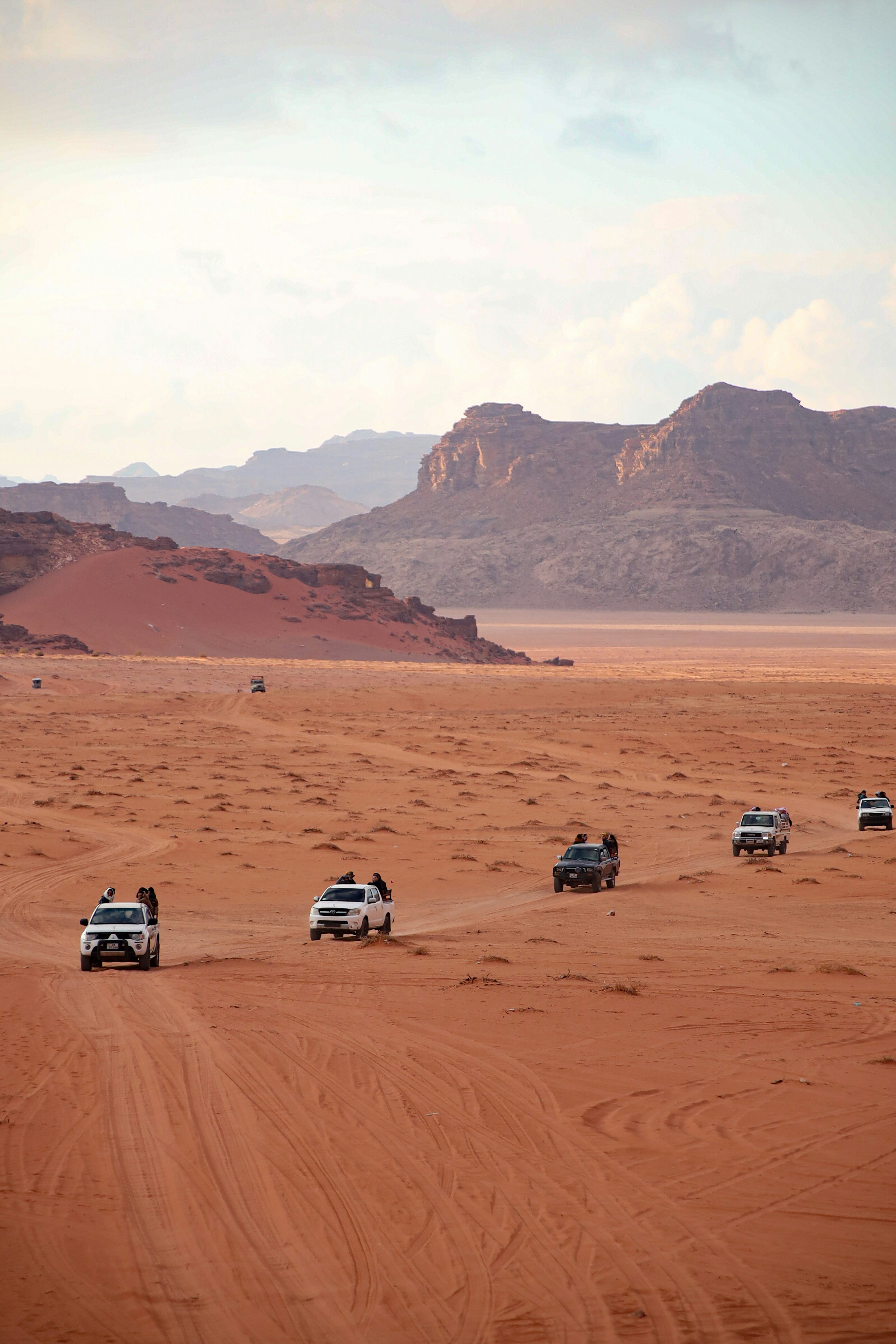 Red Dunes Convoy: White Off-Roaders Carving a Trail Through Desert Mesa Backdrop
