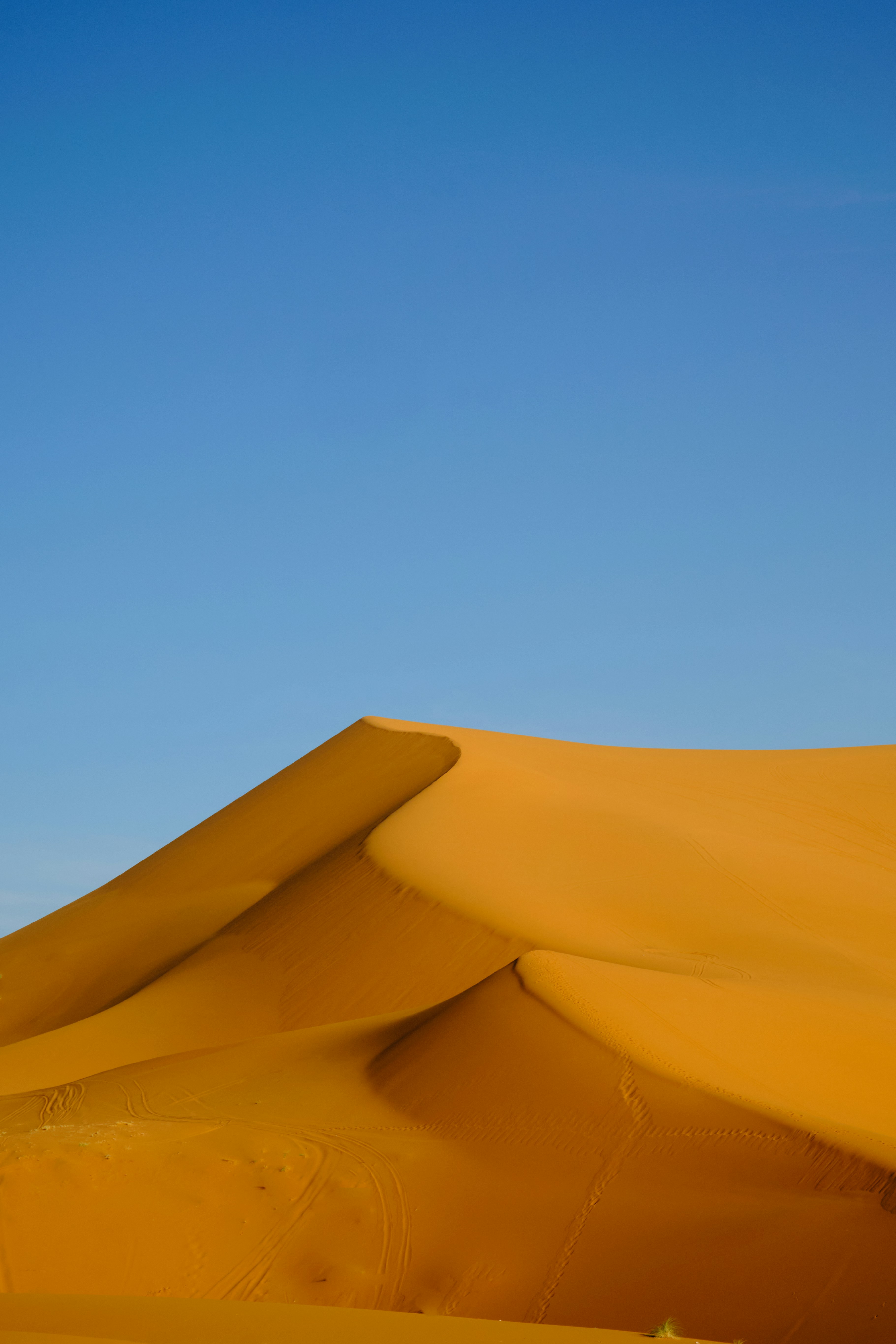 Sunlit Crest Over a Cerulean Dune Sea
