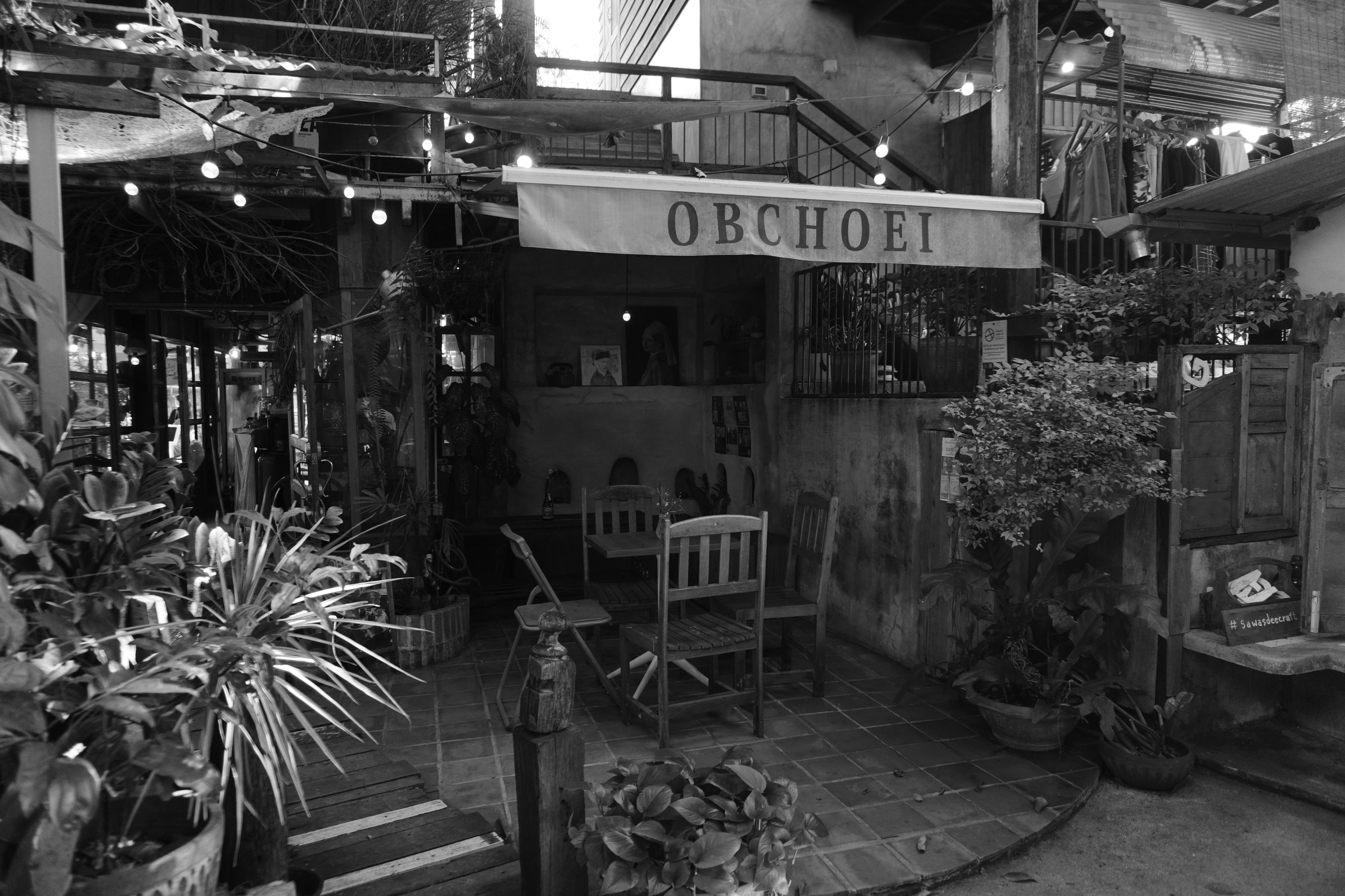 Monochrome Courtyard Café Beneath a Tangle of Lights
