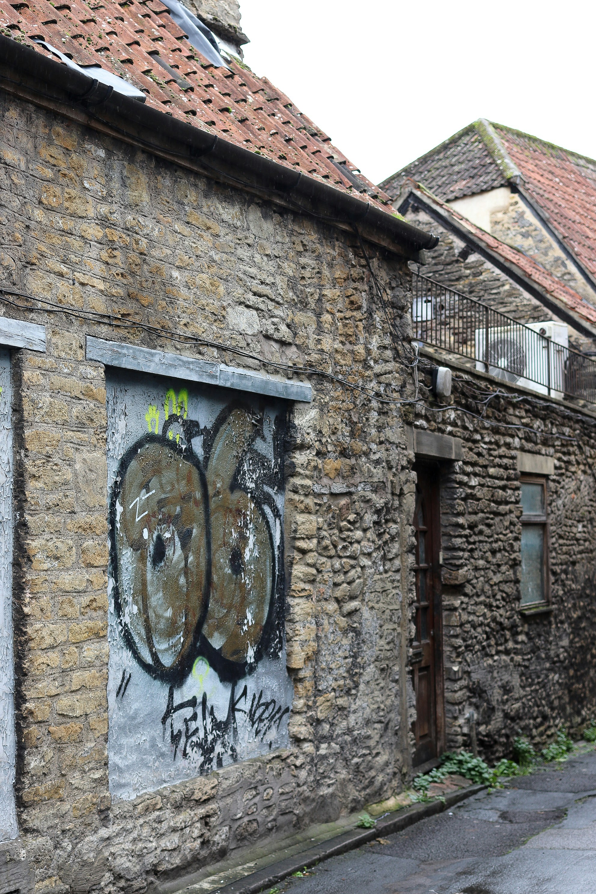 Weathered stone building adorned with graffiti, showcasing urban decay and artistic expression.