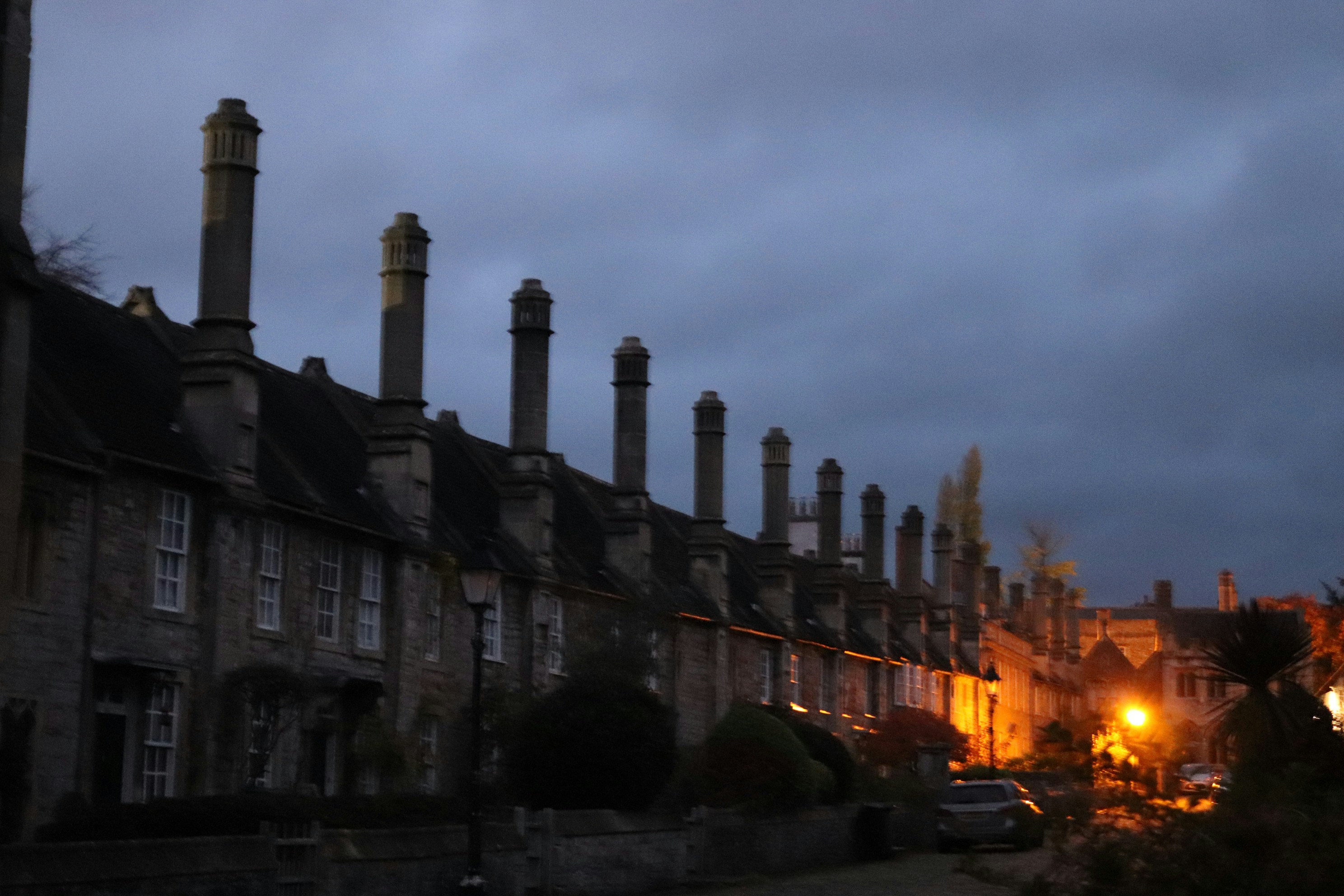 Ember Glow Along a Chimney-Lined Street at Dusk