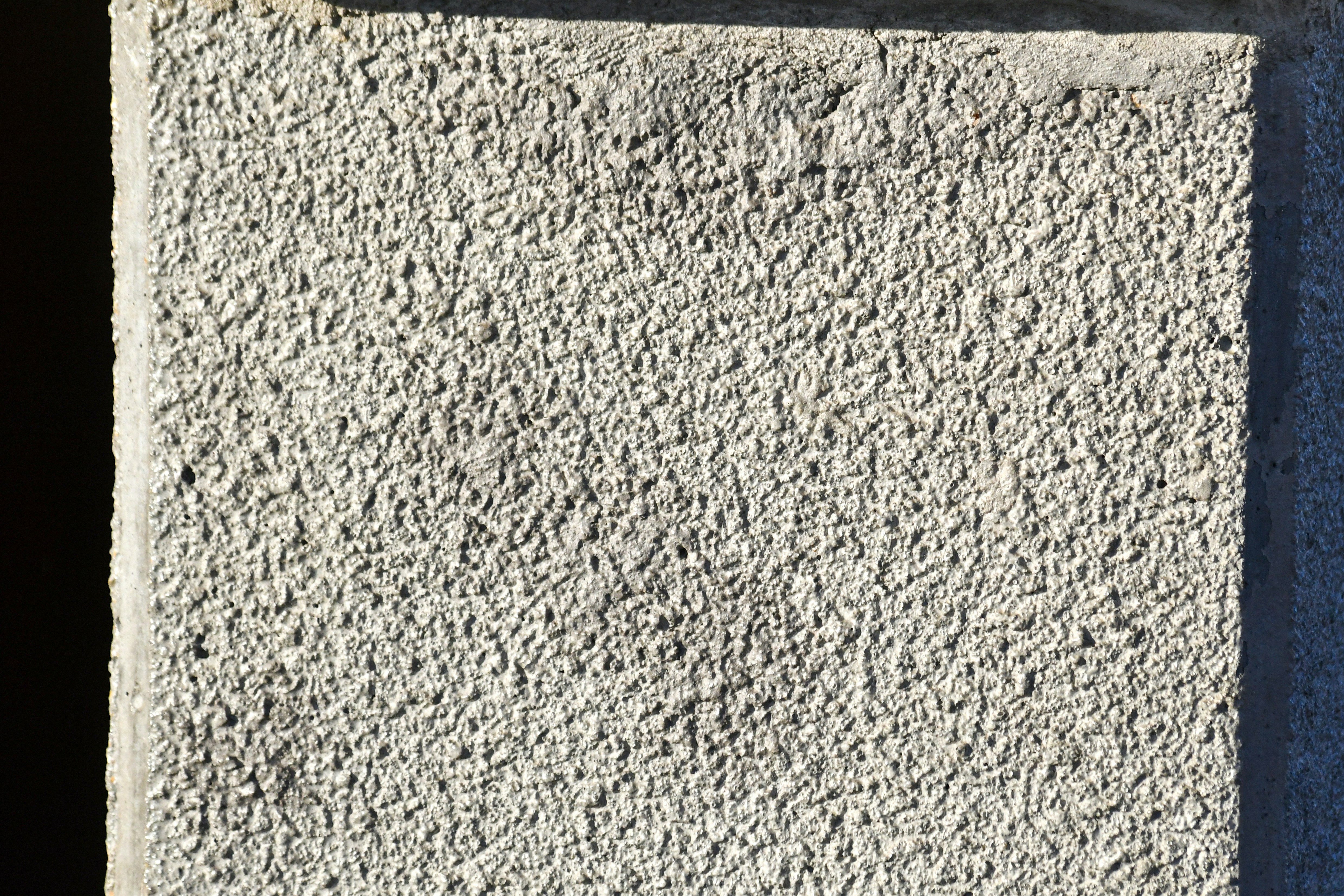 Close-up of a textured concrete surface showcasing intricate patterns and variations. Perfect for architectural or design inspiration.