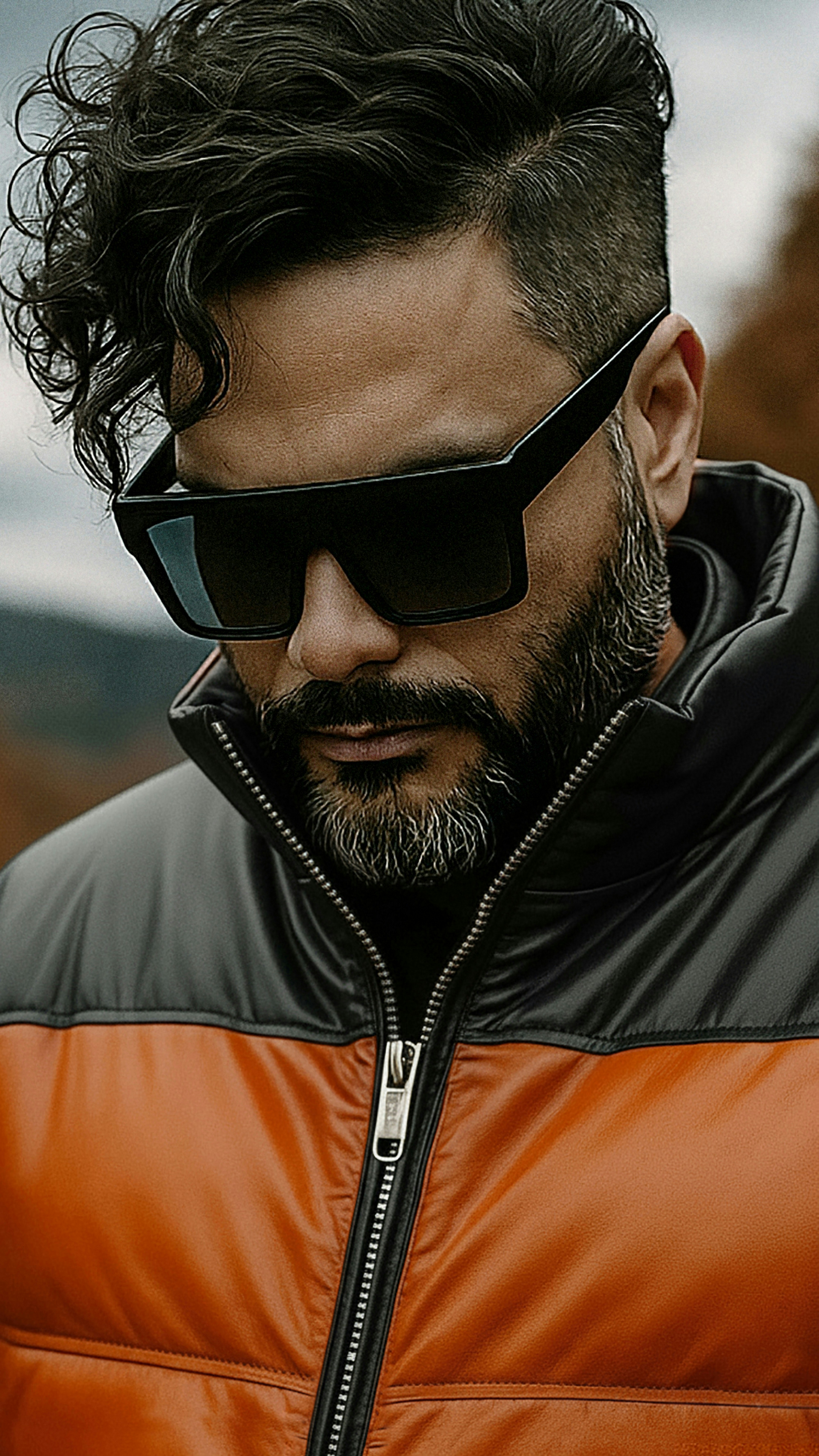 Homem com barba usando óculos escuros e jaqueta puffer foto – Imagem ...