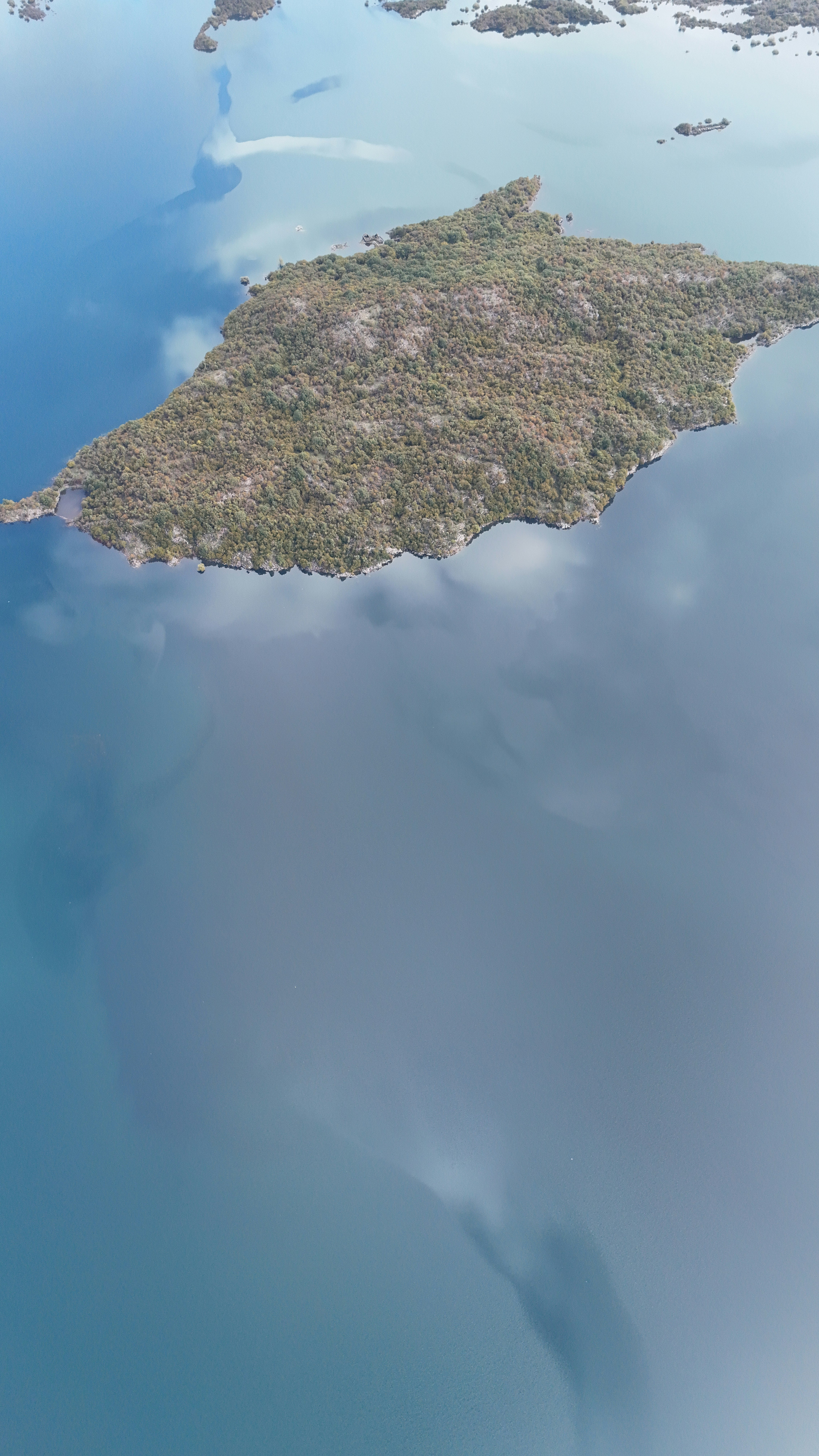 Isolated Island Fringed by a Glassy Blue Expanse