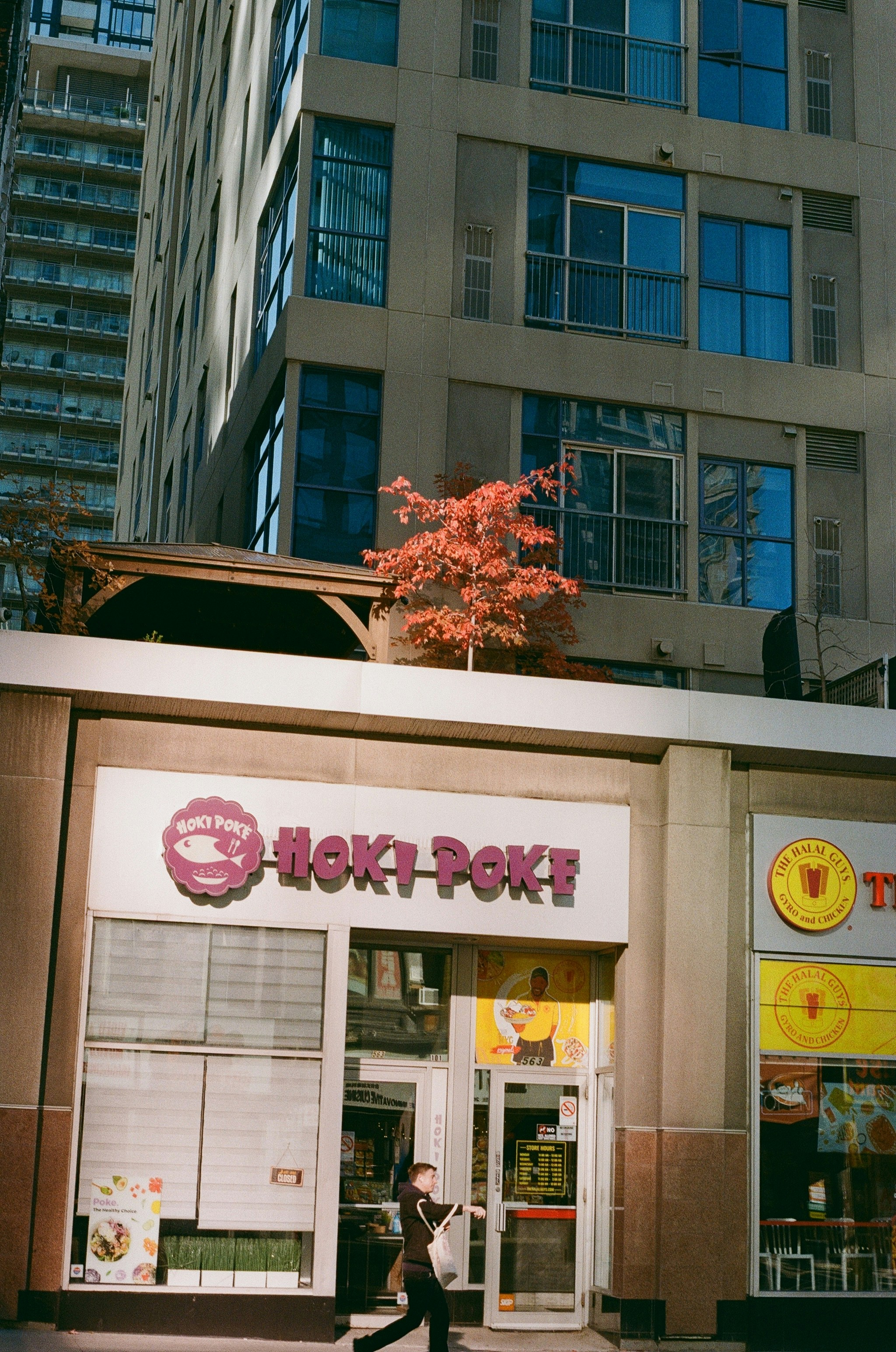 A person walks past a hoki poke restaurant. photo – Free Film Image on ...