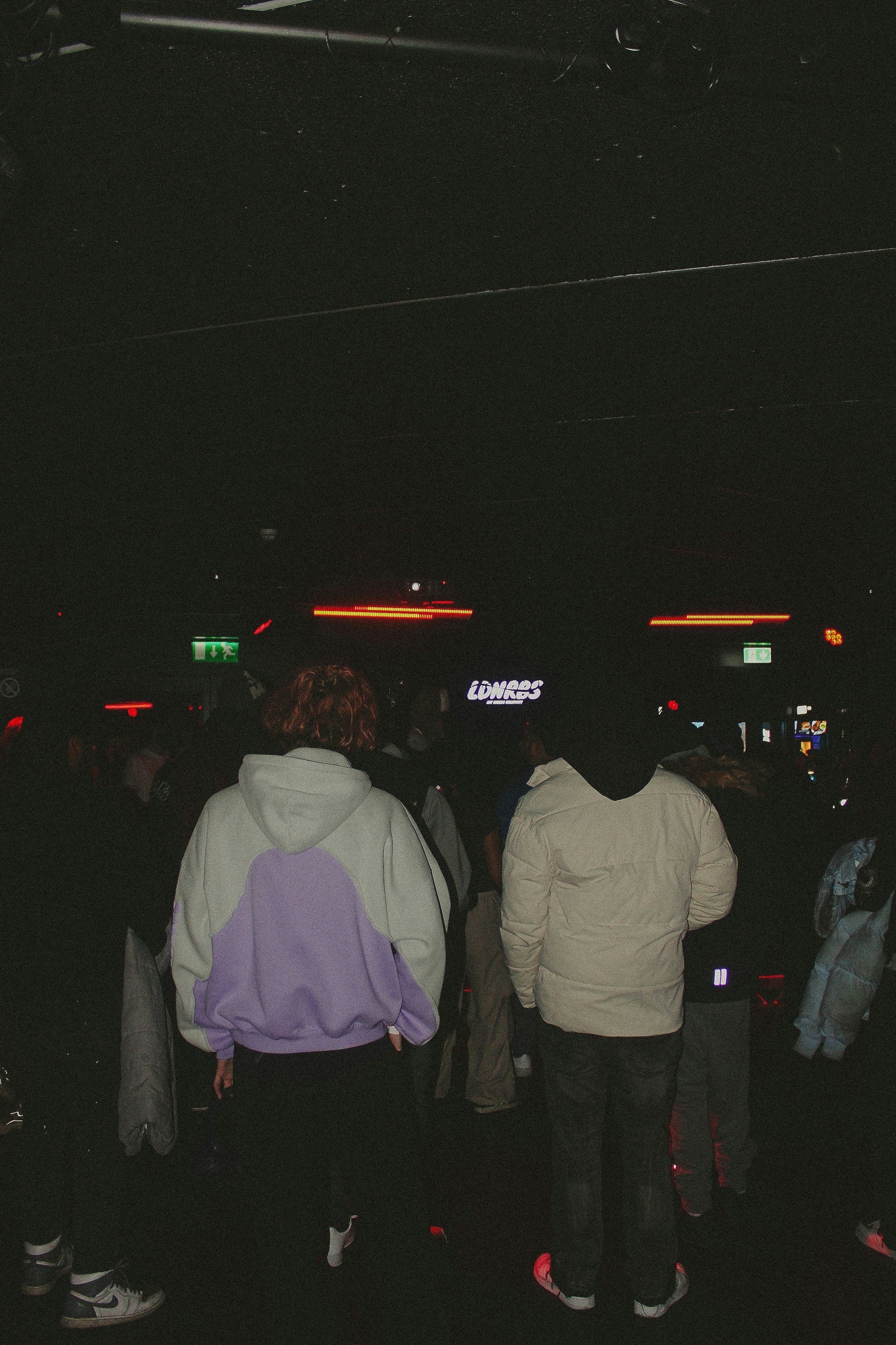 Back View in the Neon-Hush: Two Figures in a Dim Club
