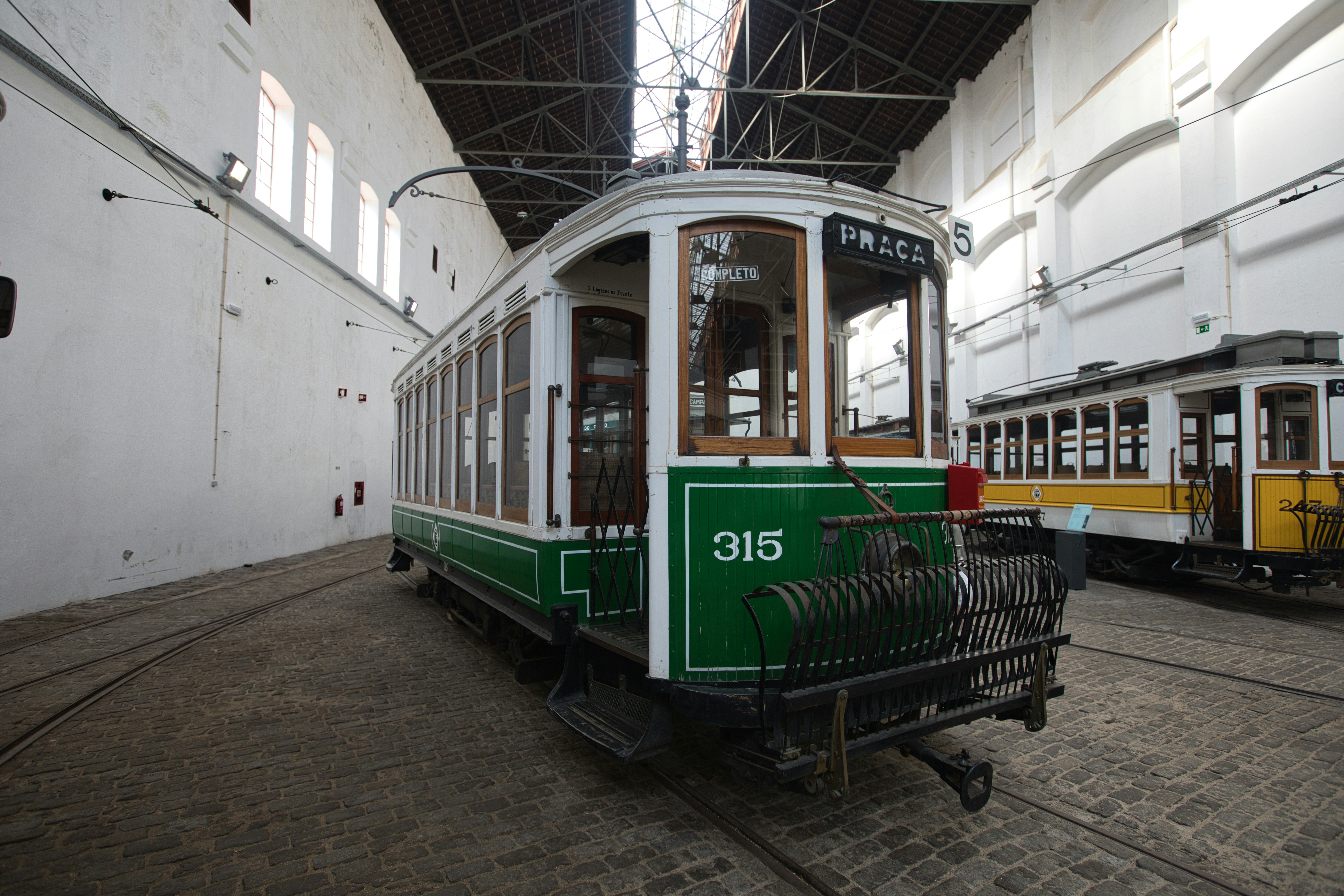 Vintage tram 315 resting in a historic depot, showcasing intricate woodwork and classic design elements. A glimpse into the evolution of urban transport.