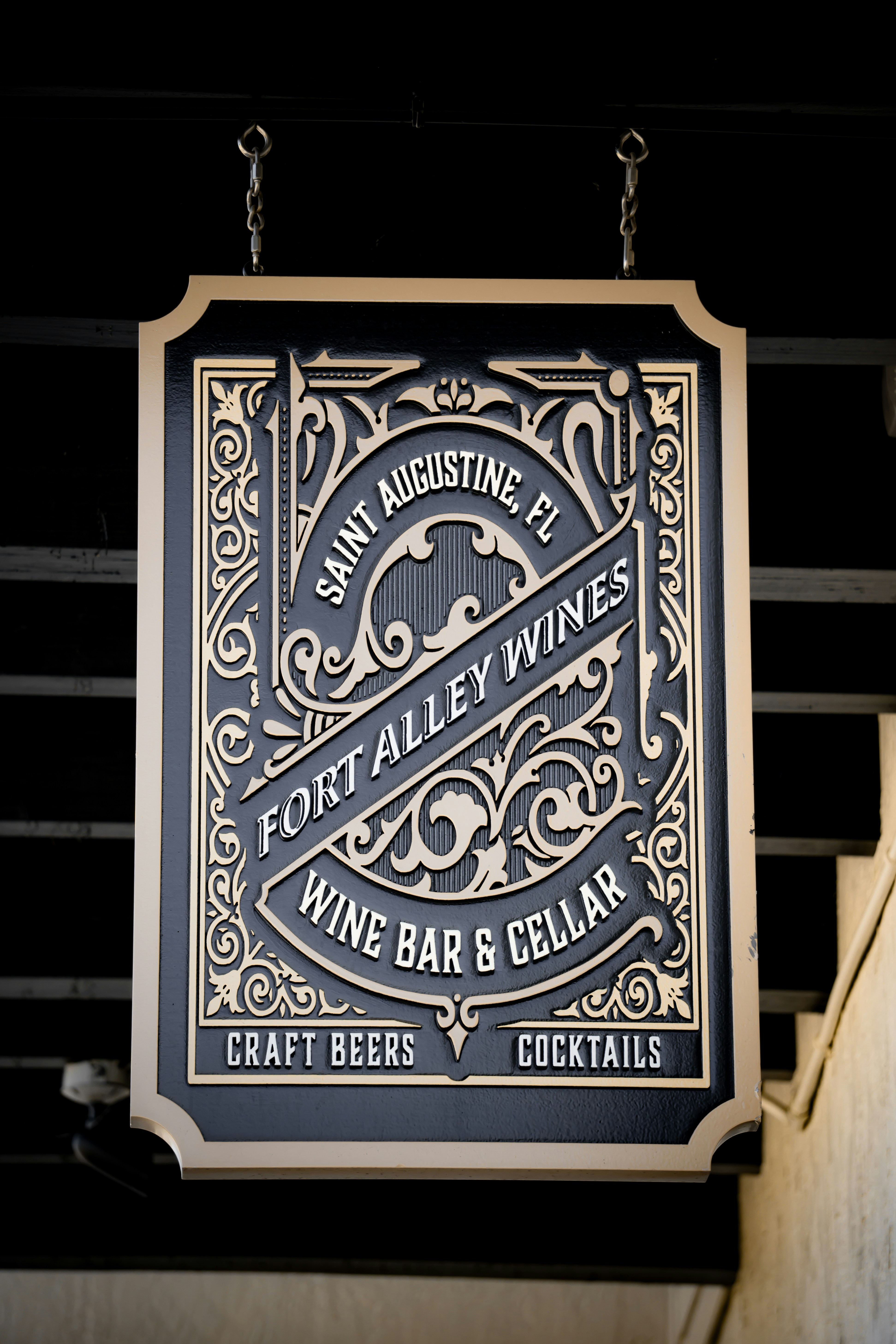 Ornate Fort Alley Wines Signboard: Craft Beers & Cocktails Under Industrial Beams