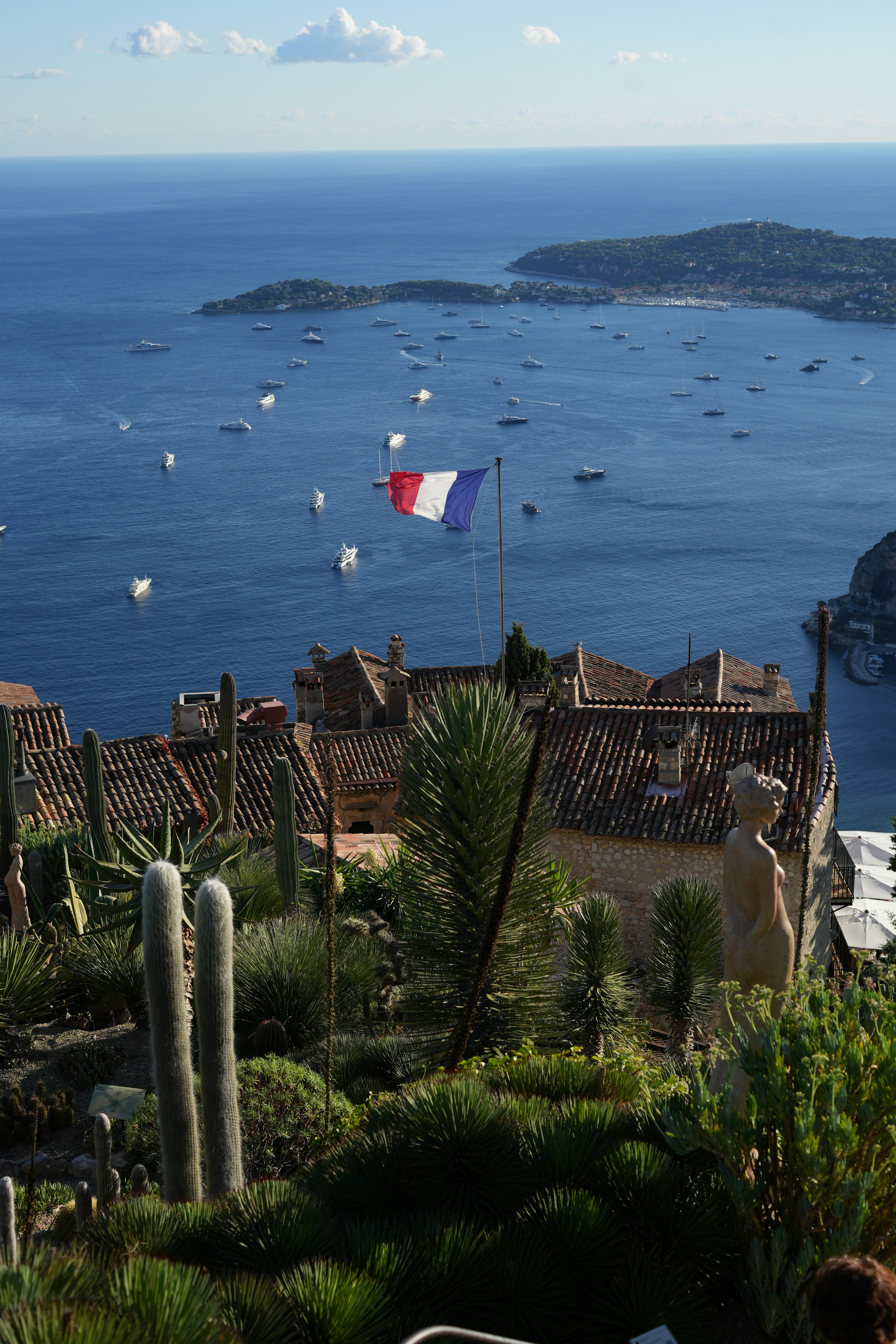 French Flag Over a Sunlit Riviera Village Above a Harbor Teeming with Boats