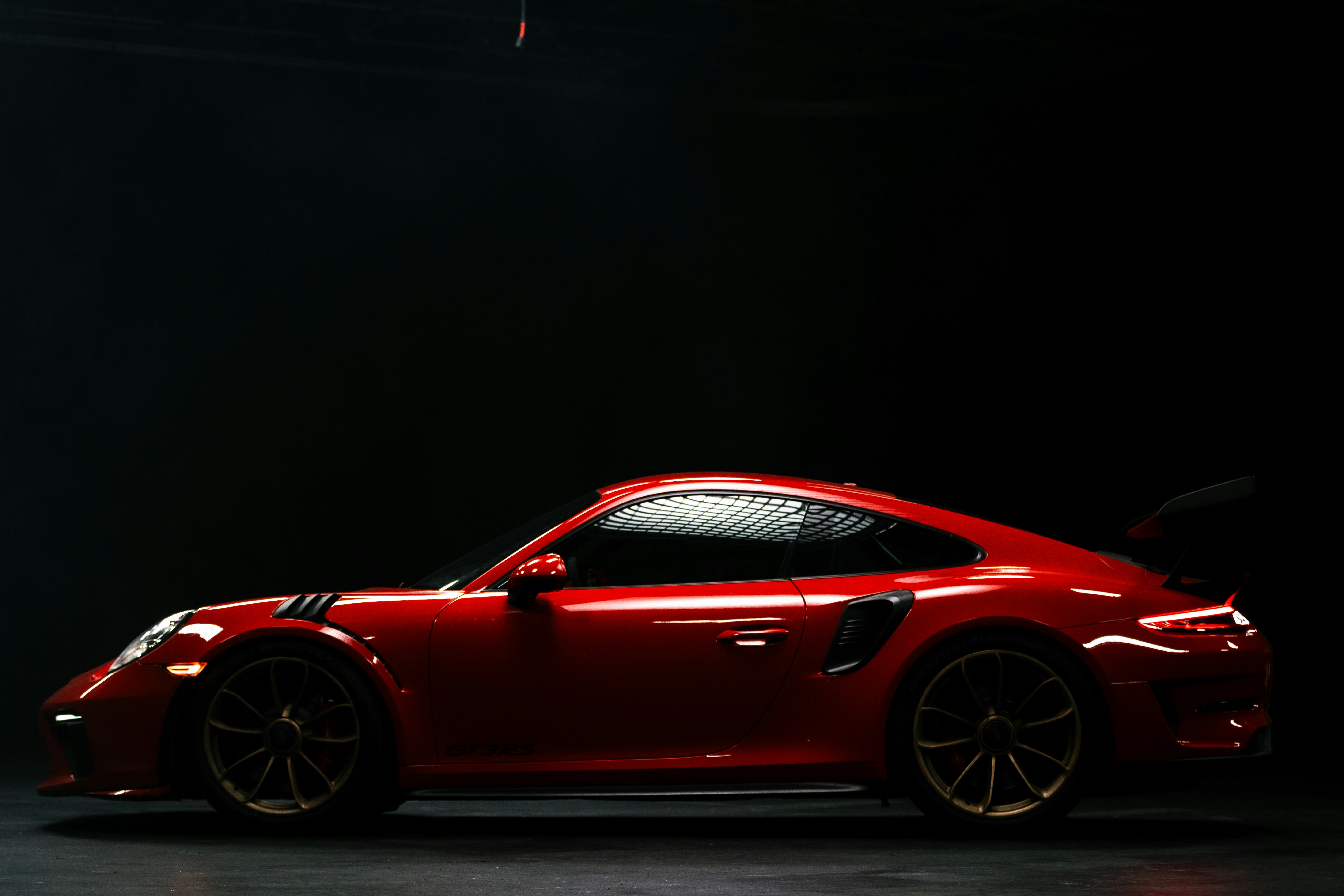 A sleek red sports car showcased in dramatic lighting, emphasizing its aerodynamic design and powerful stance.