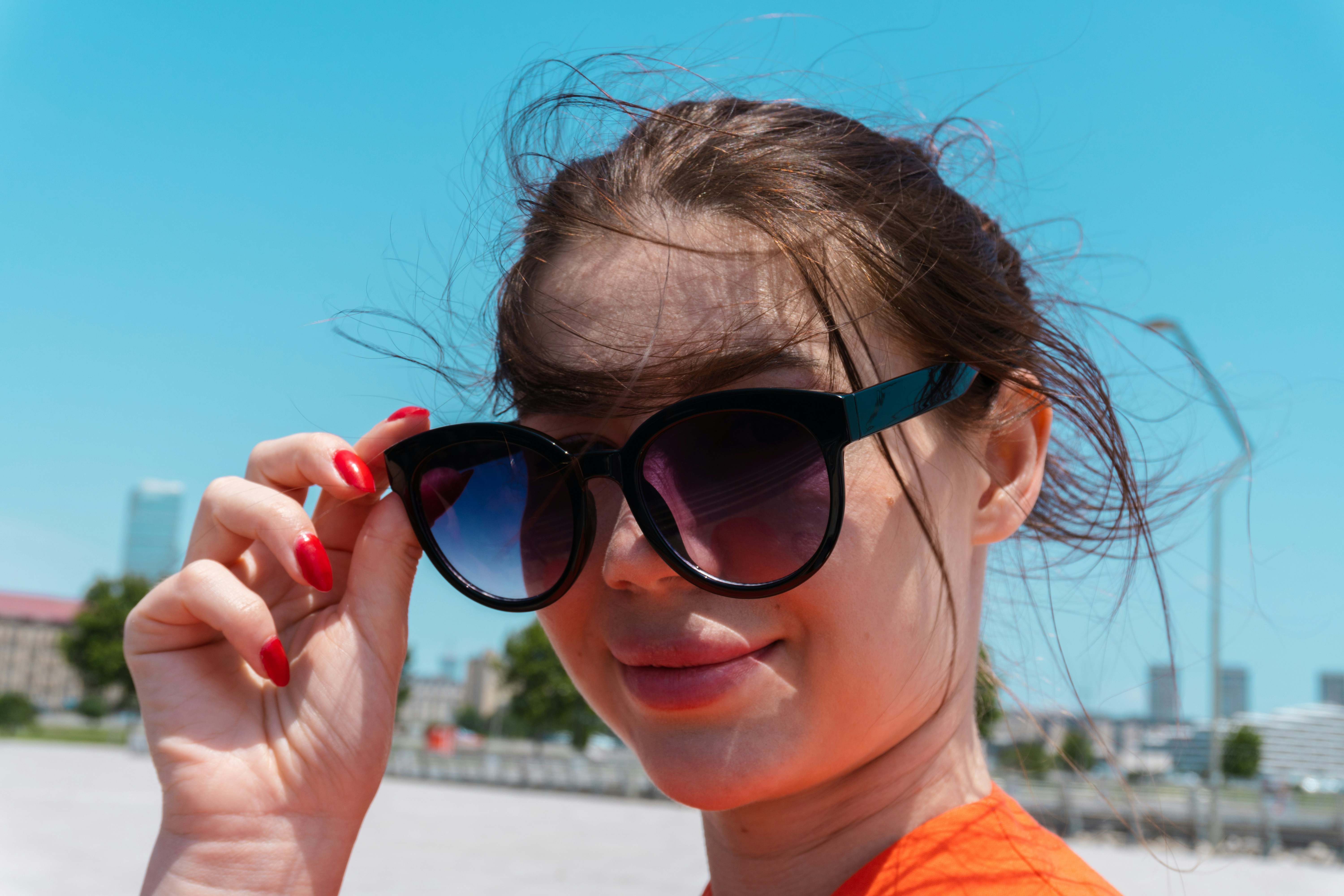 Sunlit Close-Up: Oversized Sunglasses and a City Sky