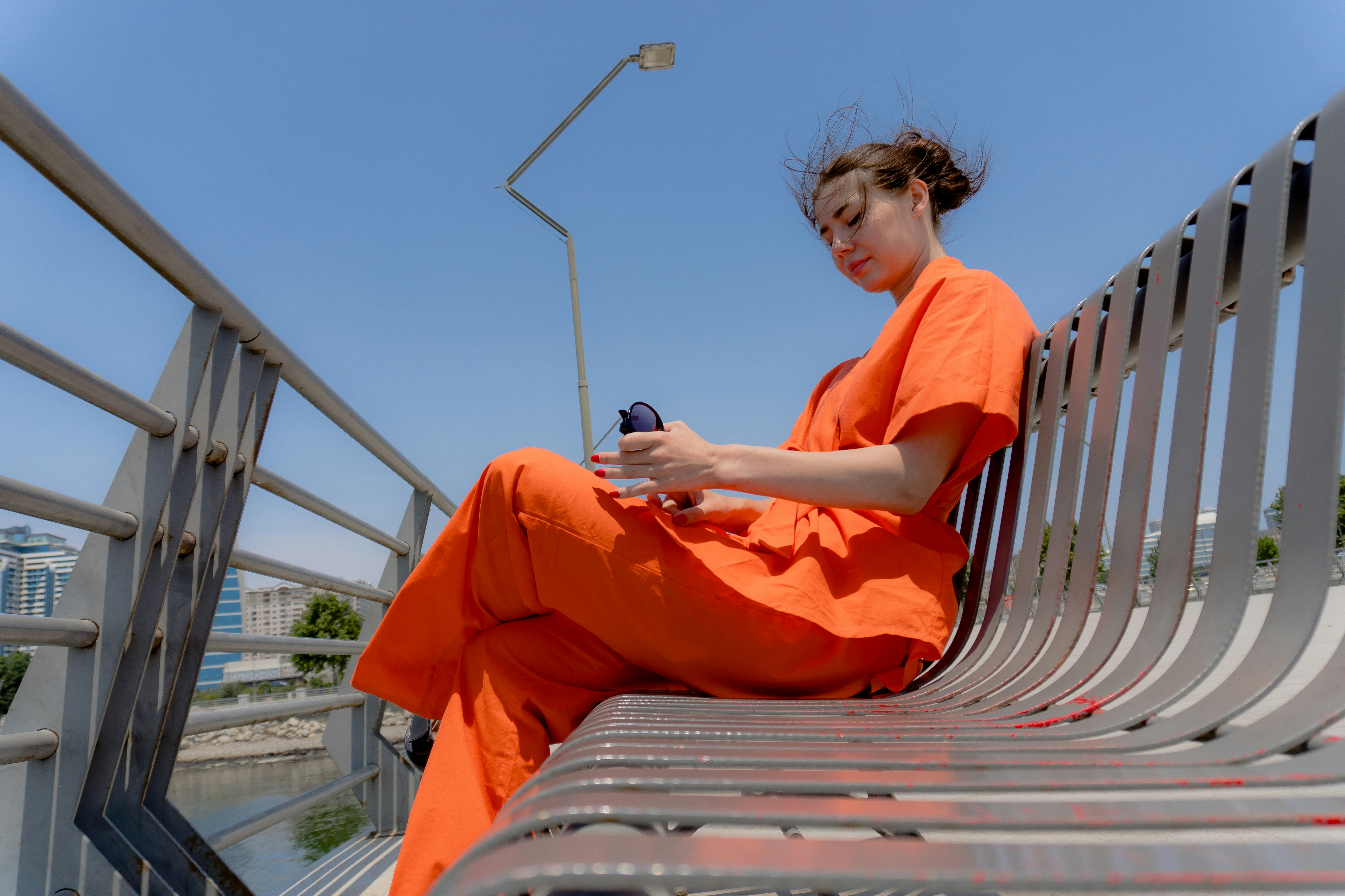 Crimson Overpass: A Quiet Portrait on the Metal Bench