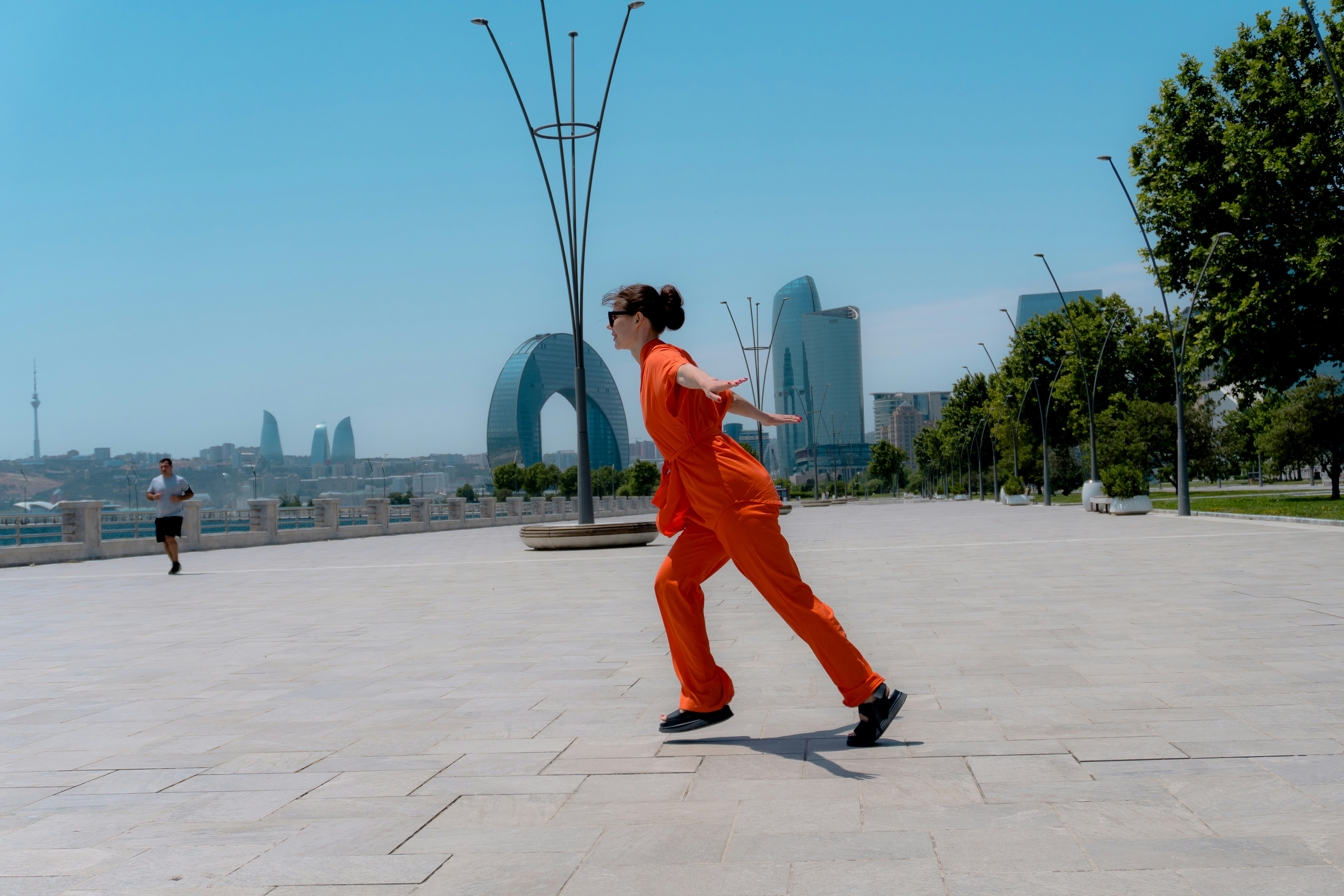 Mid-Stride in Orange: A Sunny Run Along the Modern Waterfront