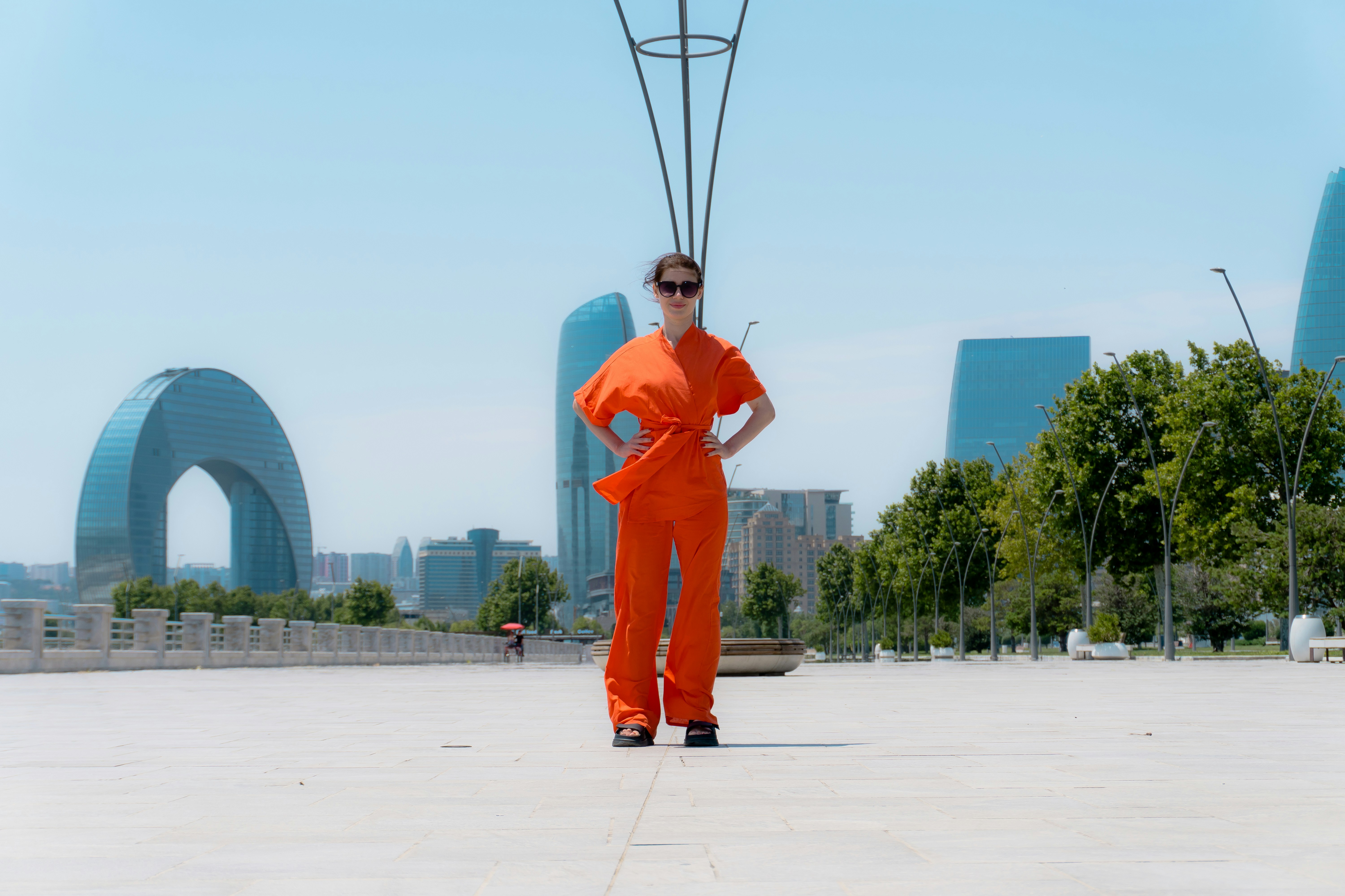 Orange Sentinel on a Sunlit Plaza Before a Futuristic Skyline