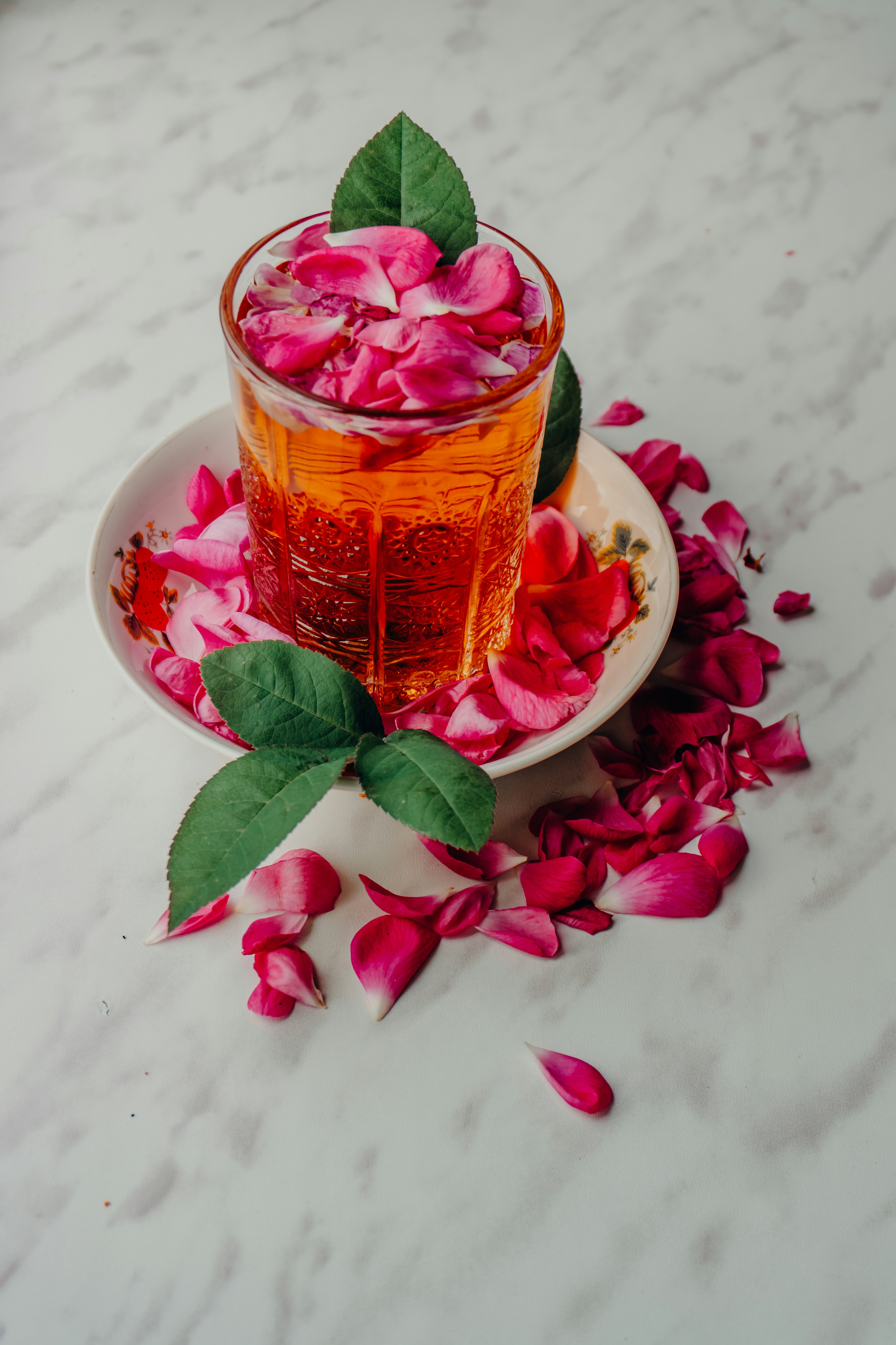 Rose Petal Glow: Amber Tea in a Glass on Marble