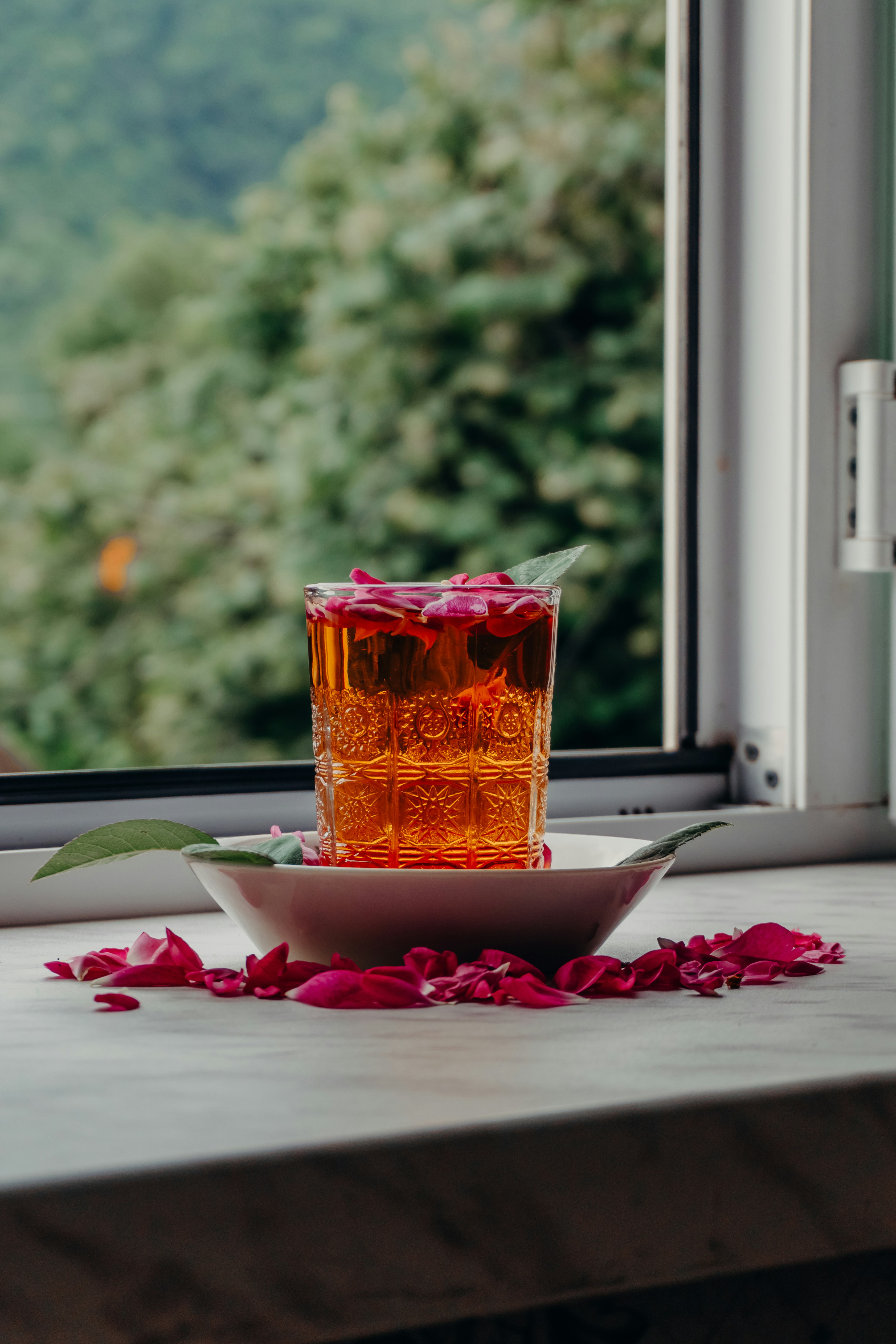 Amber Glass on a Window Sill, Petals around a Quiet Drink