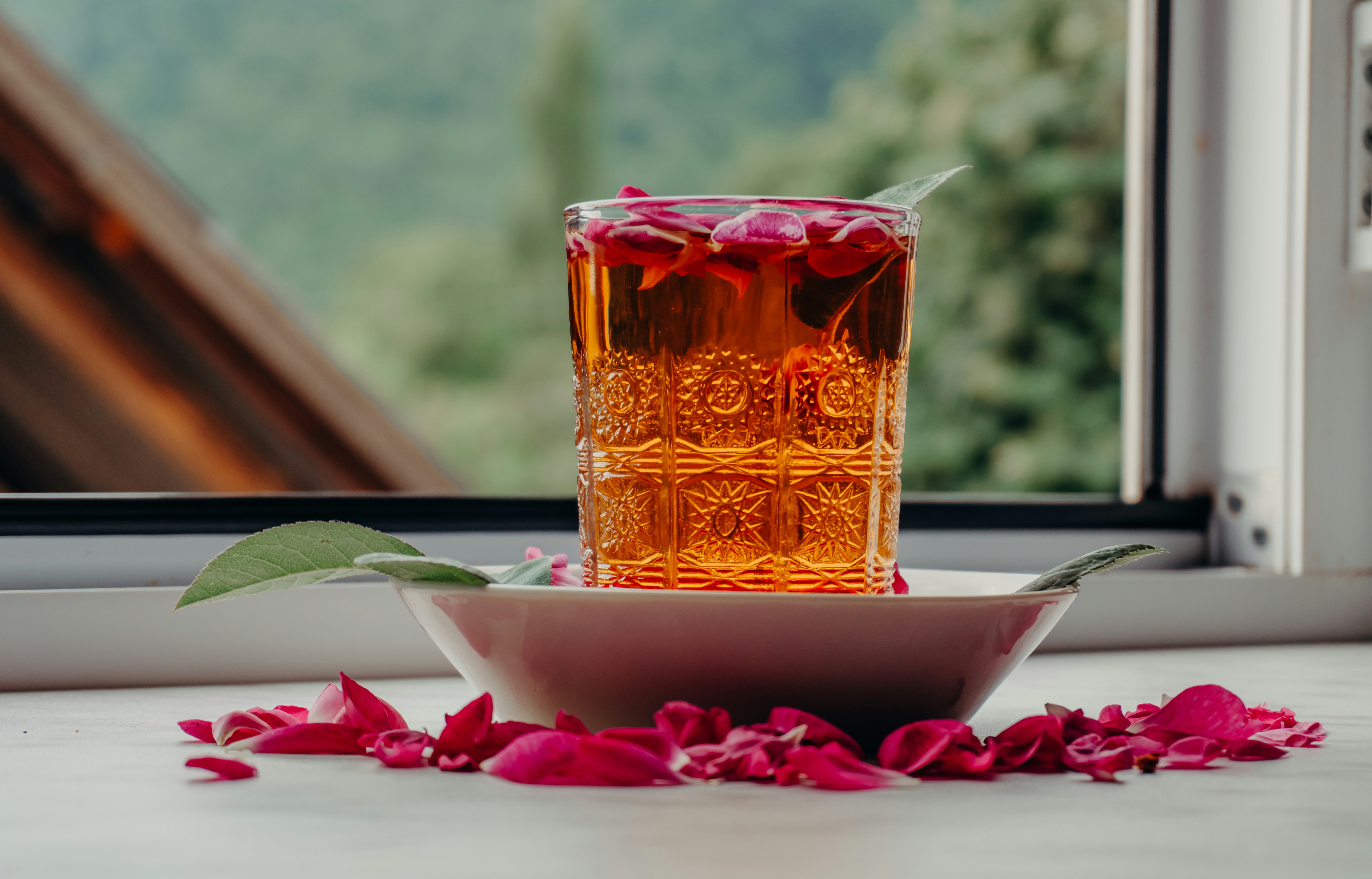 Heritage Glass on a Windowsill Blooming with Petal Remnants
