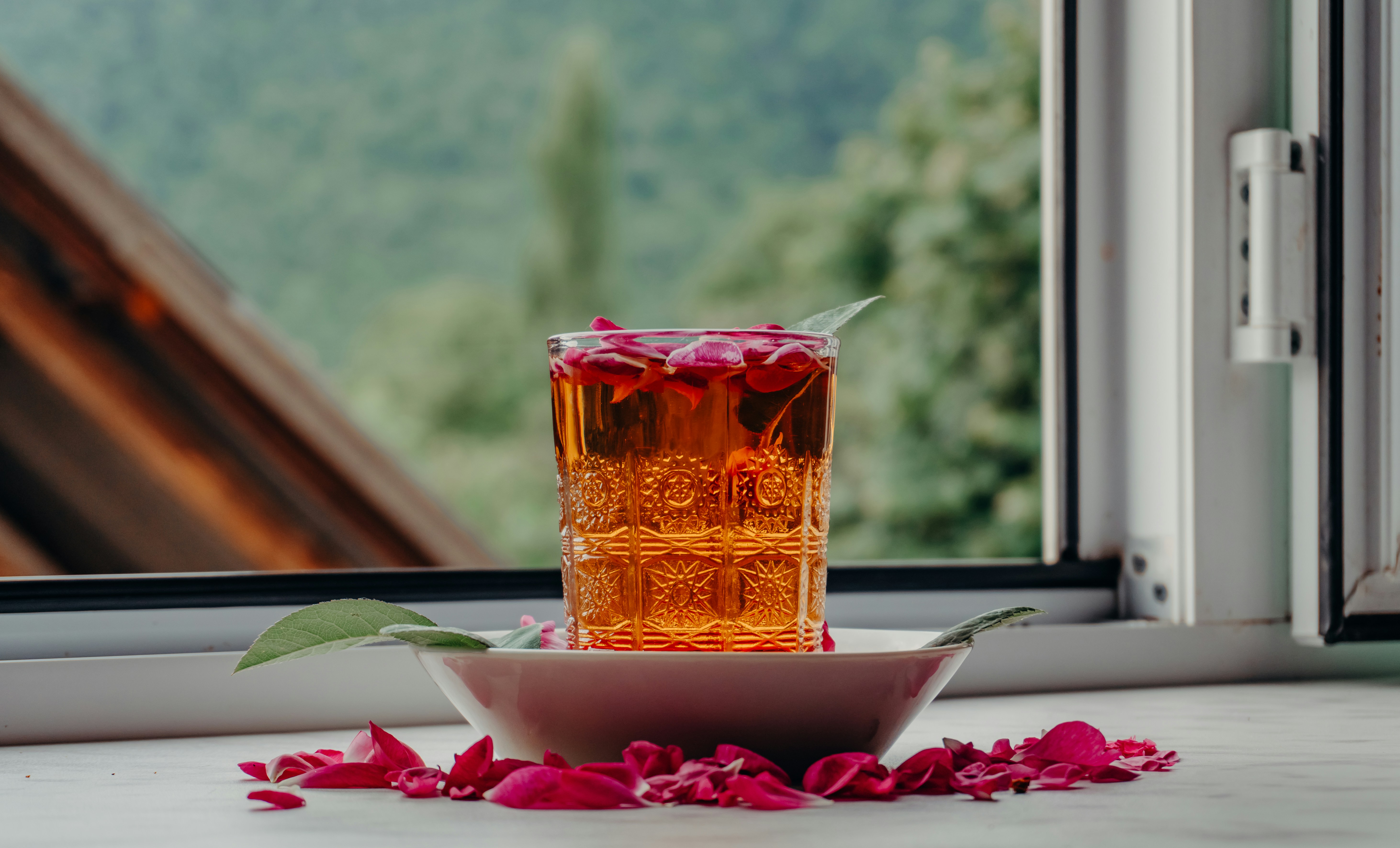 Amber Iced Glass Framed by Spring Petals on a Windowsill
