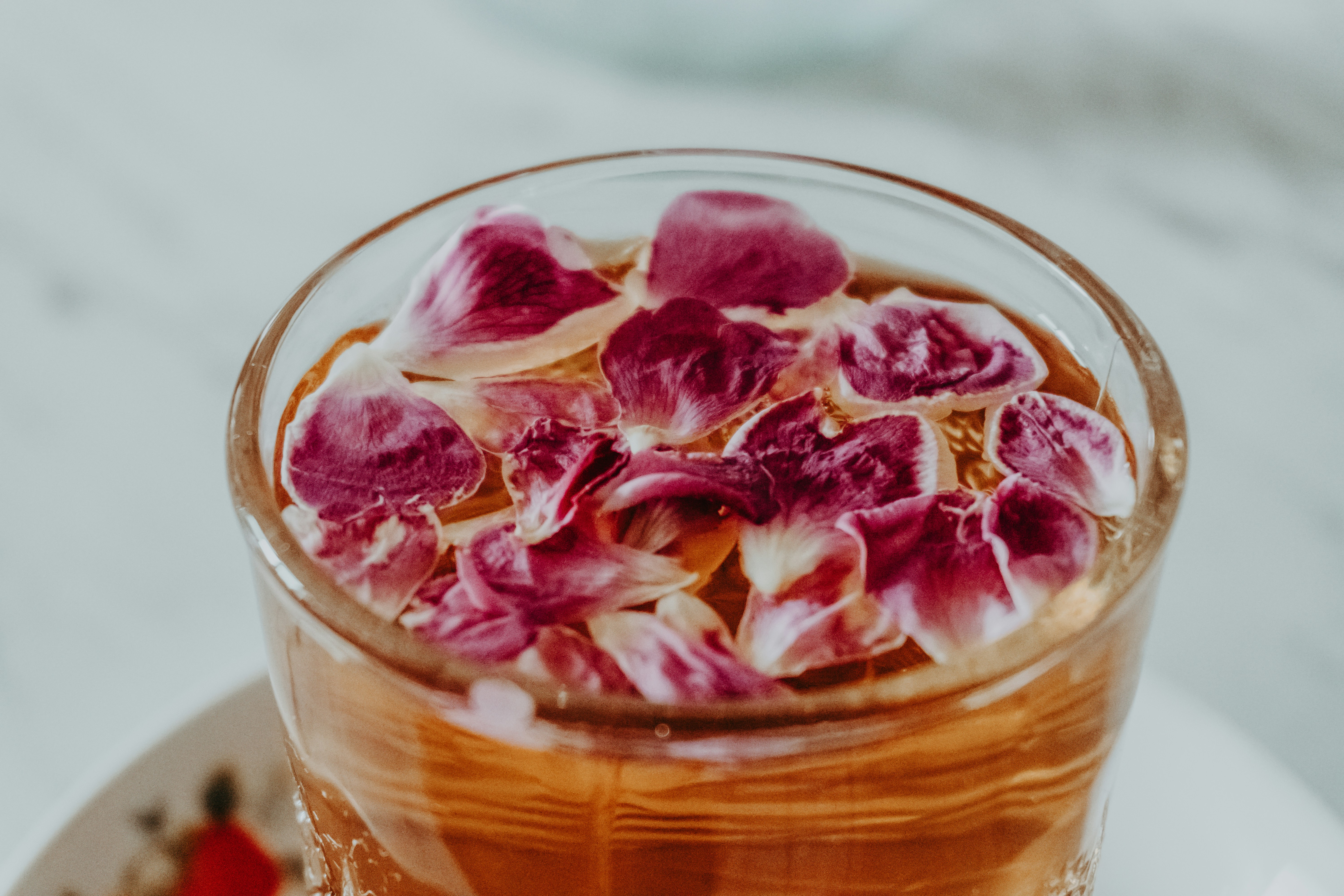 Rosy Petal Infusion on Marble: A Crystal Glass Moment