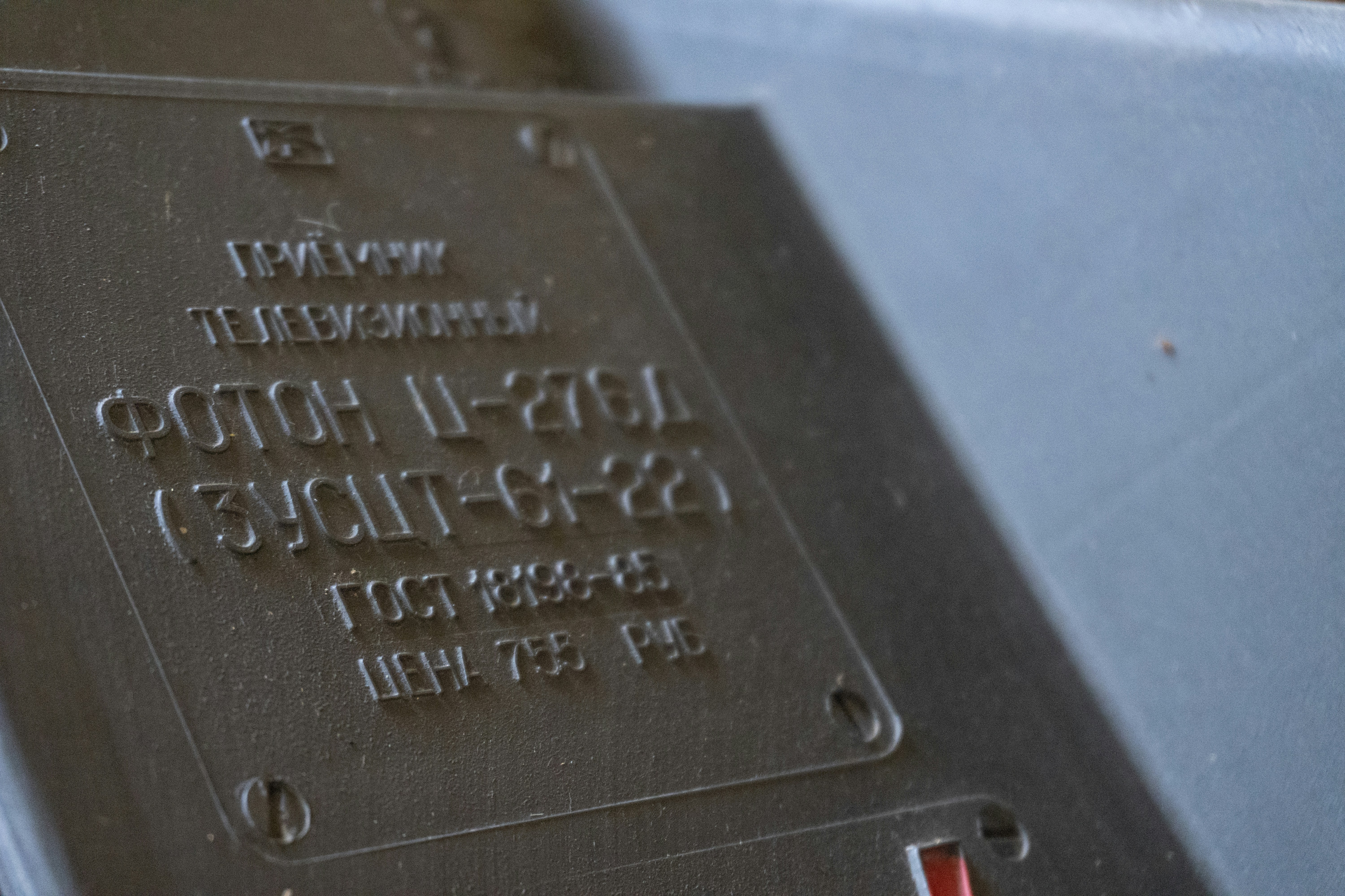 Close-up of a metallic identification plate from a Soviet-era device, featuring Cyrillic text and technical specifications.