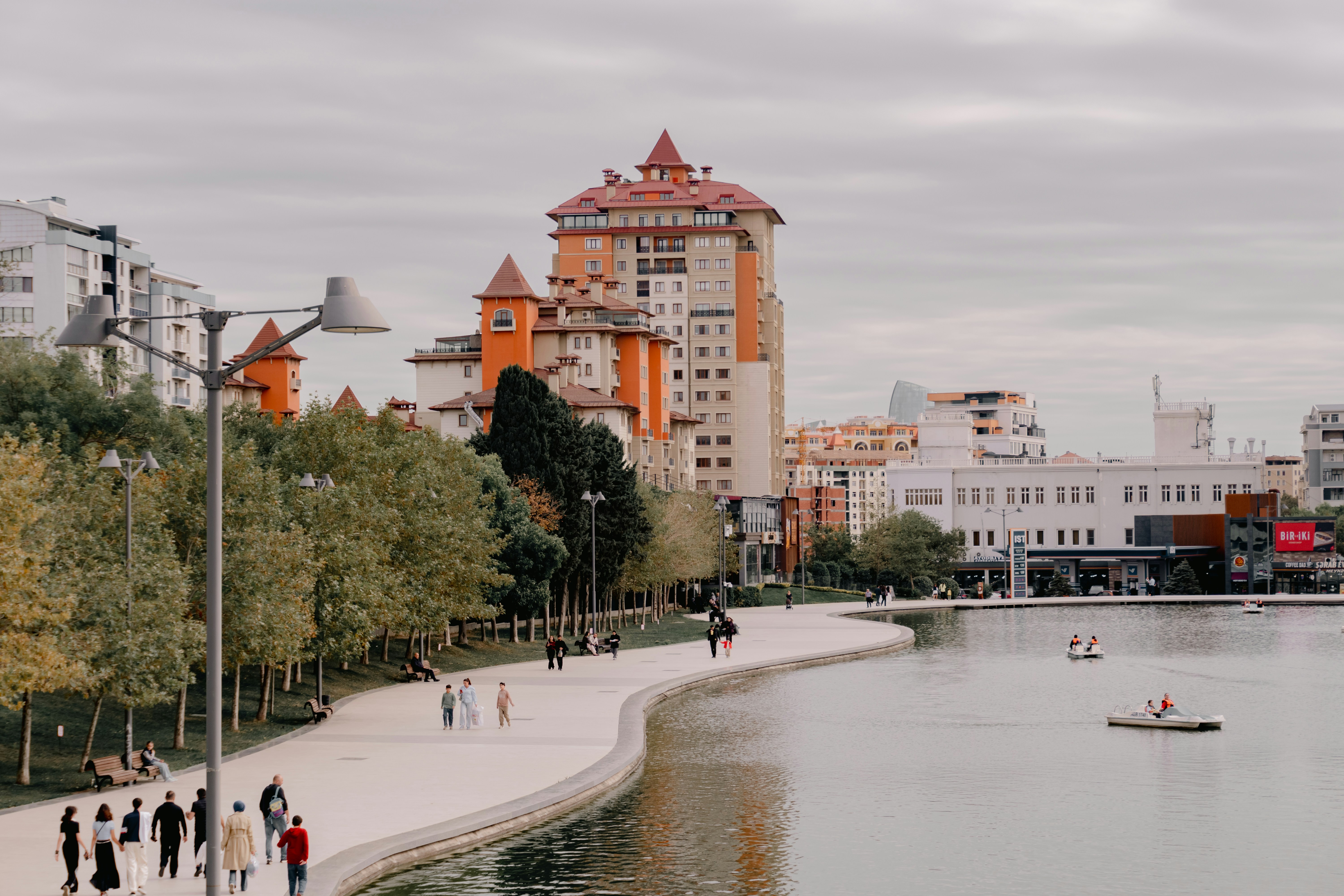 Orange-Topped Towers Framing a Quiet Riverside Promenade