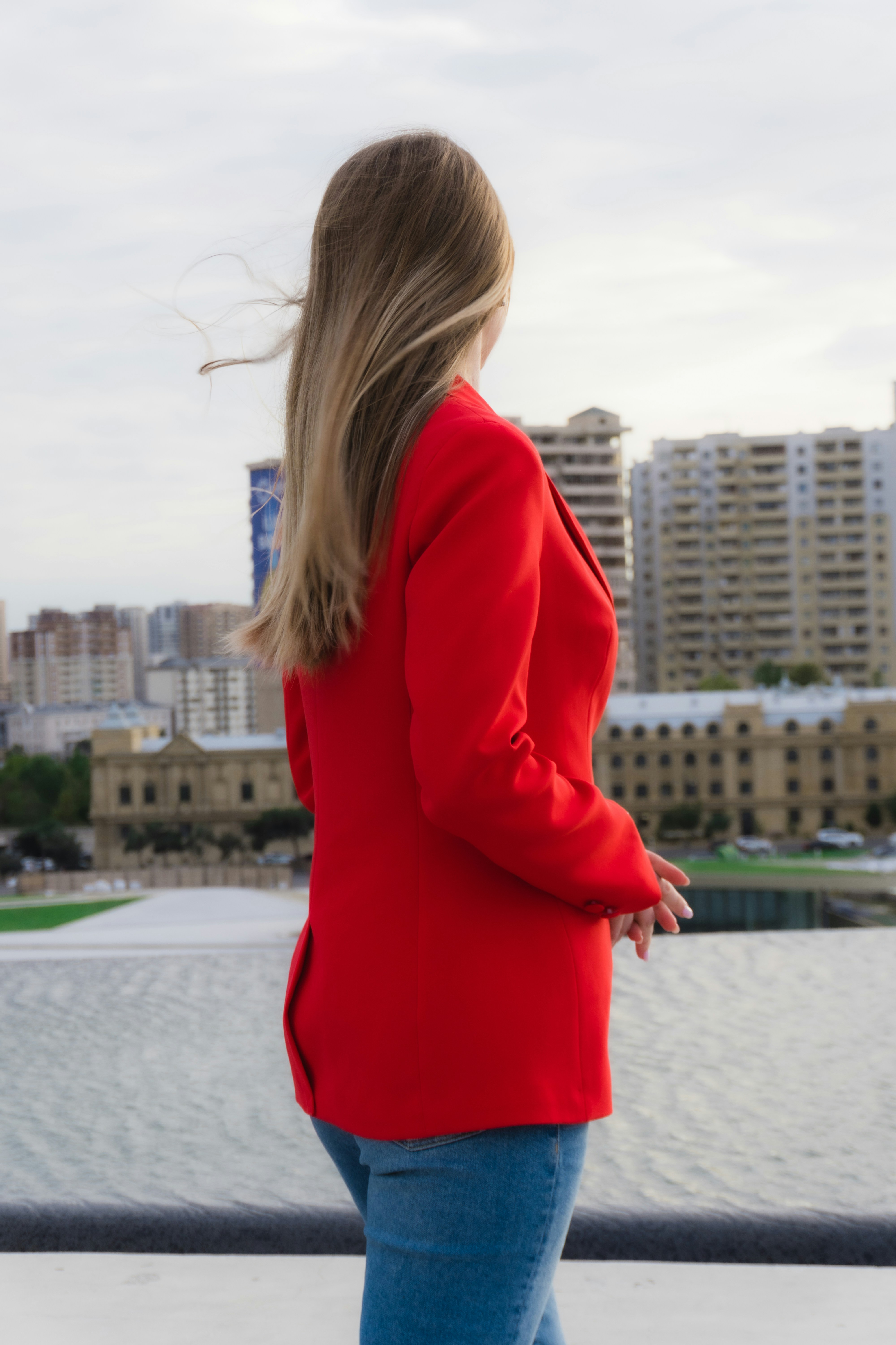 Red Blazer, Quiet Horizon: A Woman Overlooking the City