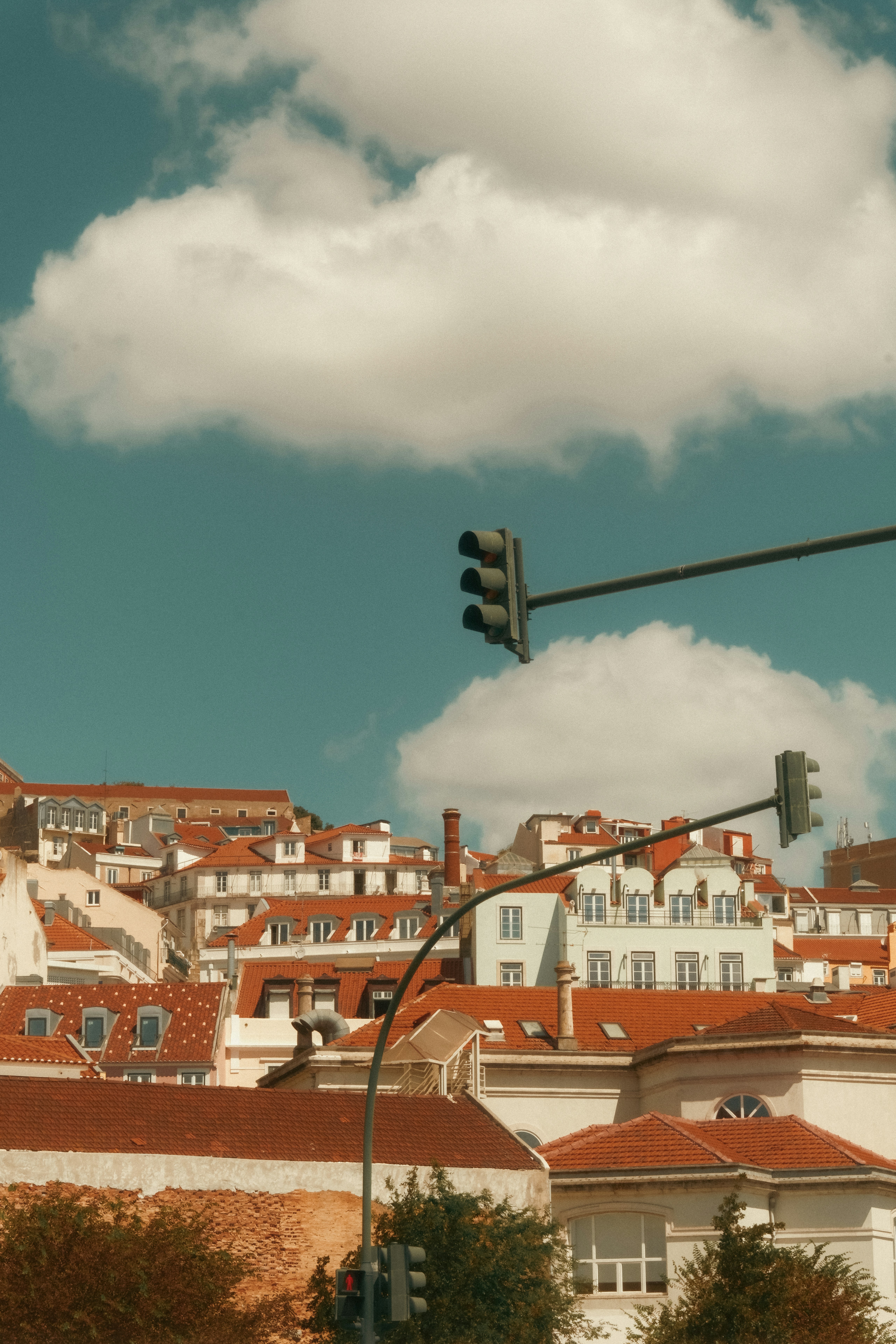Traffic Light Over a Sea of Terracotta Roofs Under a Turquoise Sky
