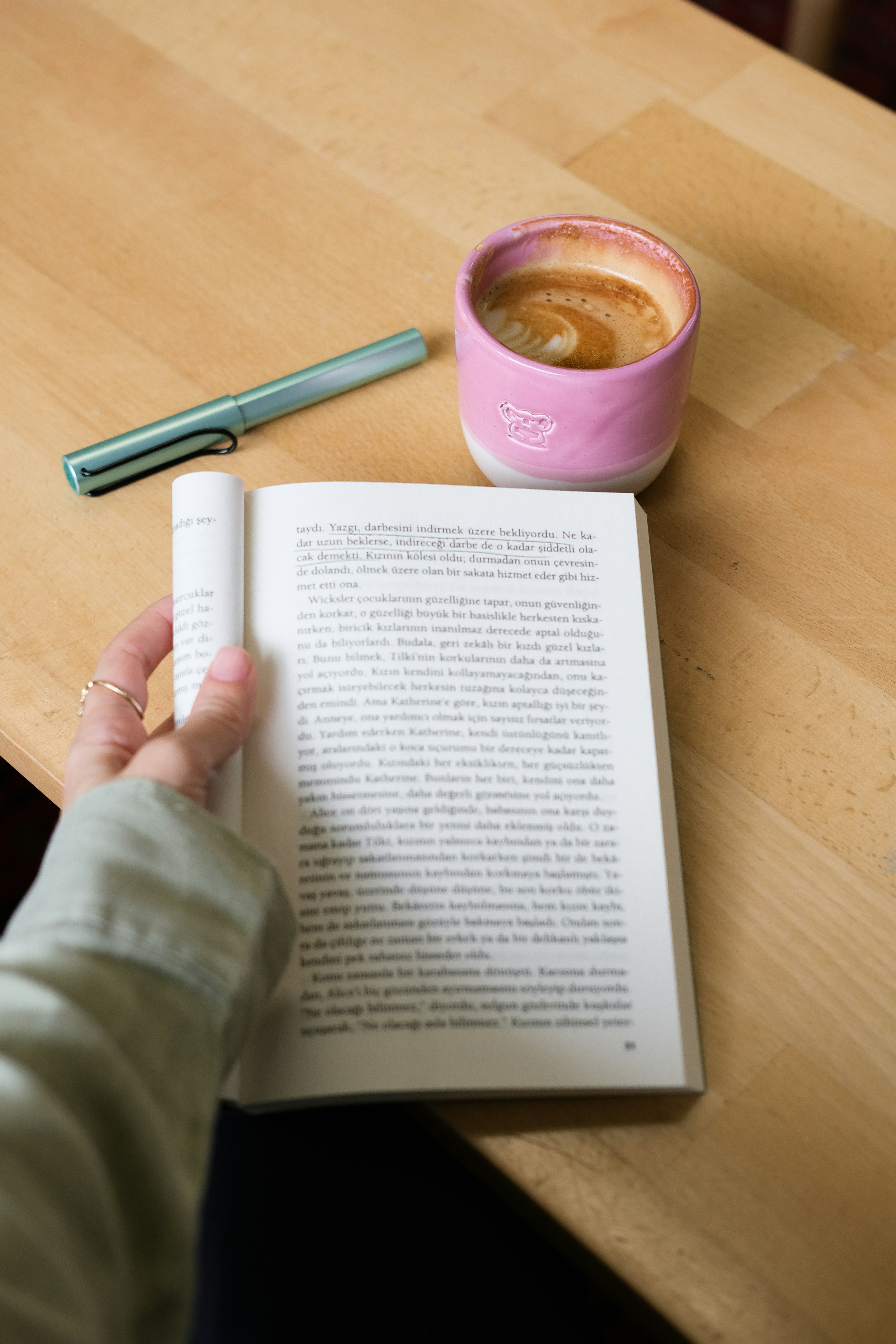 Turning Pages and Gentle Steam: A Pink Latte, Teal Pen, and a Quiet Morning Table