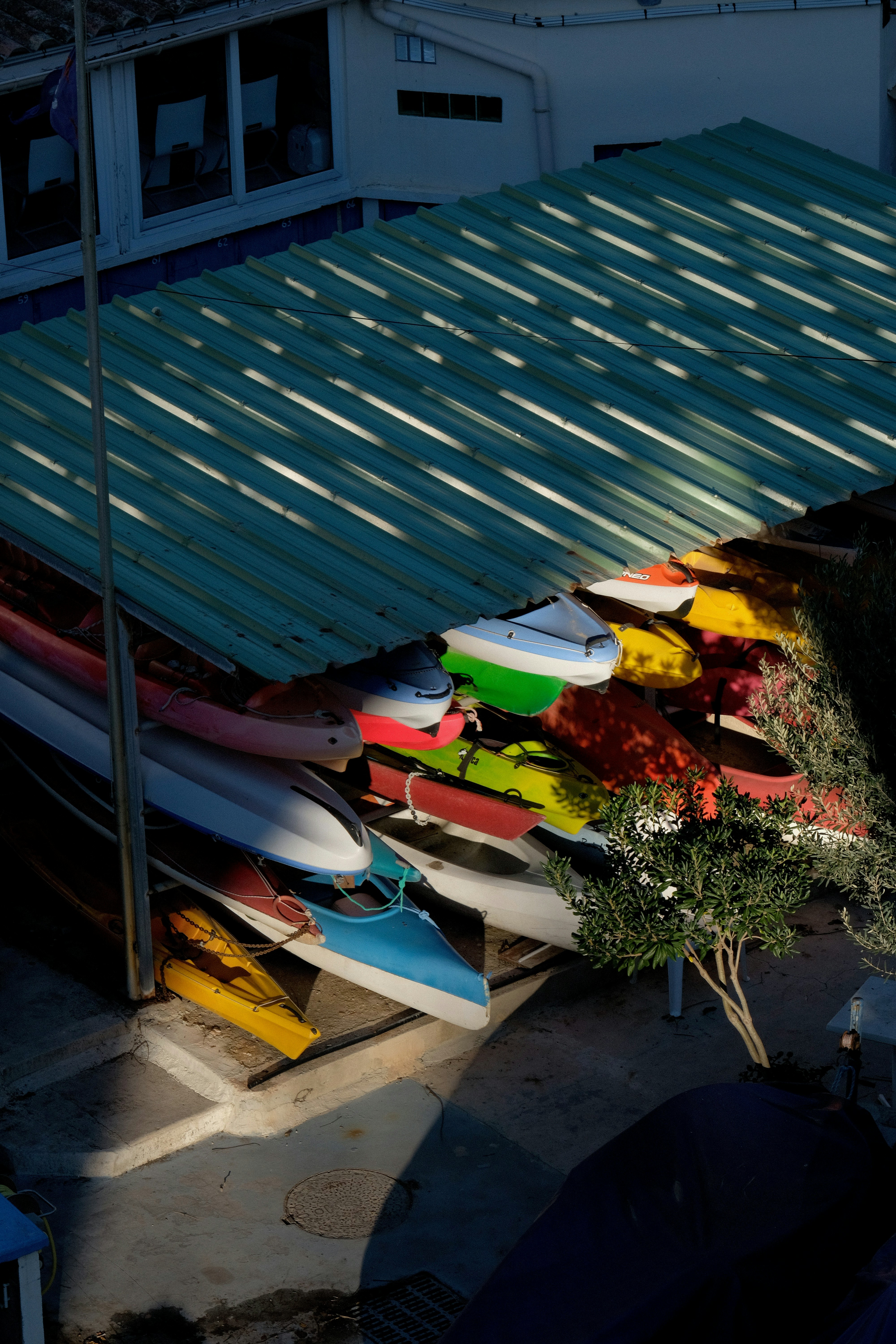 Teal Corrugated Roof Cradles a Rainbow of Kayaks