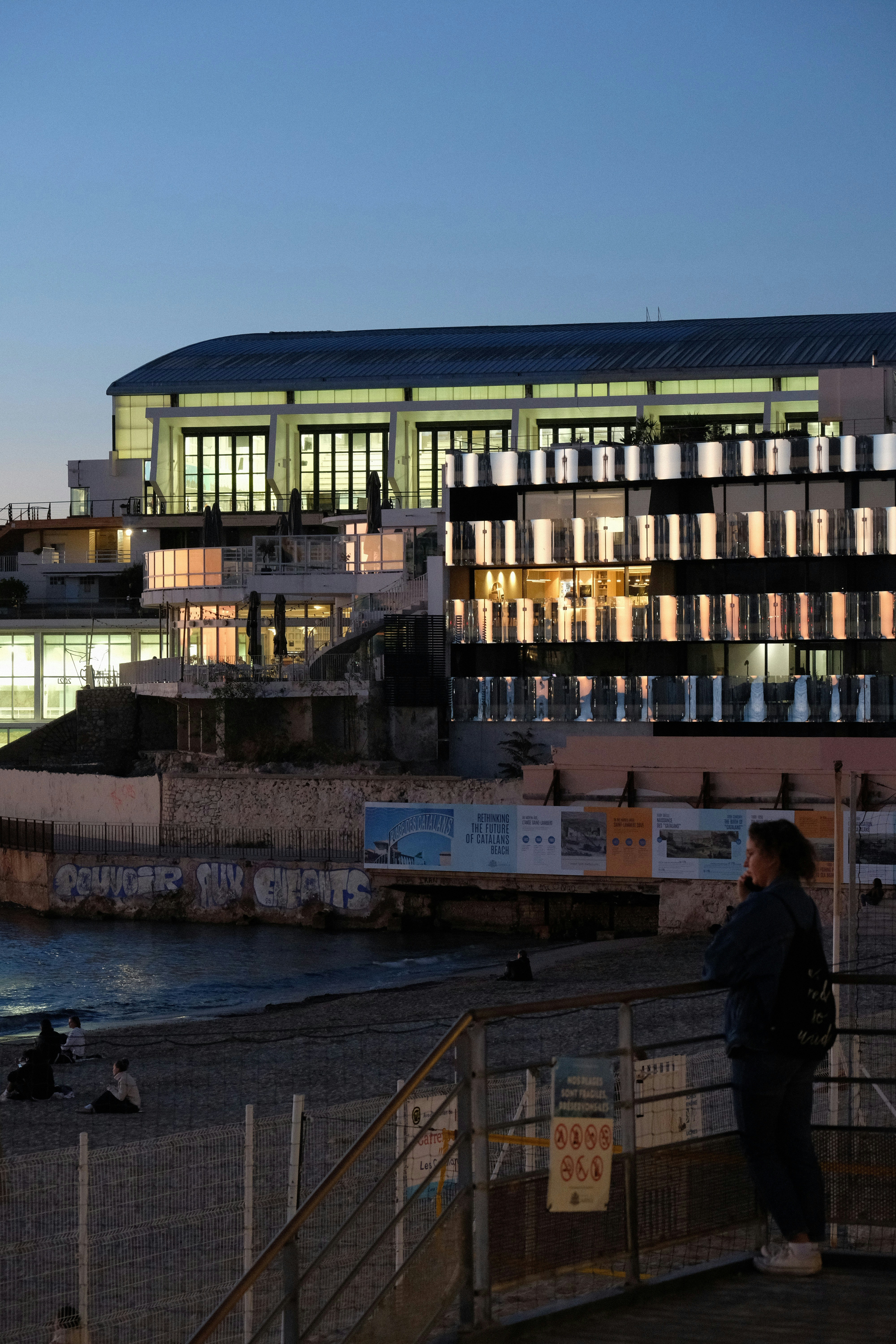 Dusk in Glass: Harborfront Facade Ablaze with Interior Light