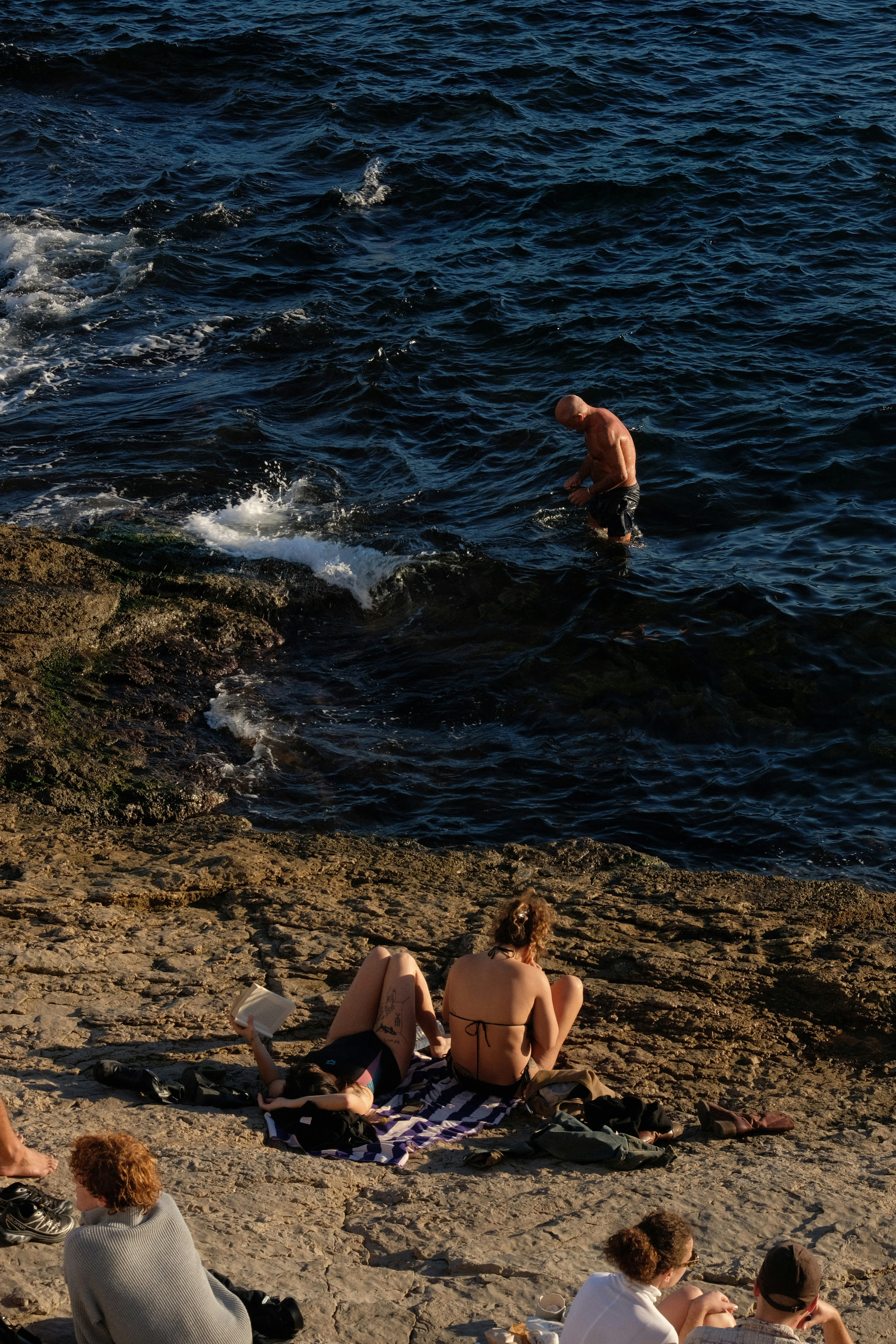 Edgework at Sea: a solitary swimmer skims the cobalt edge of a granite shore