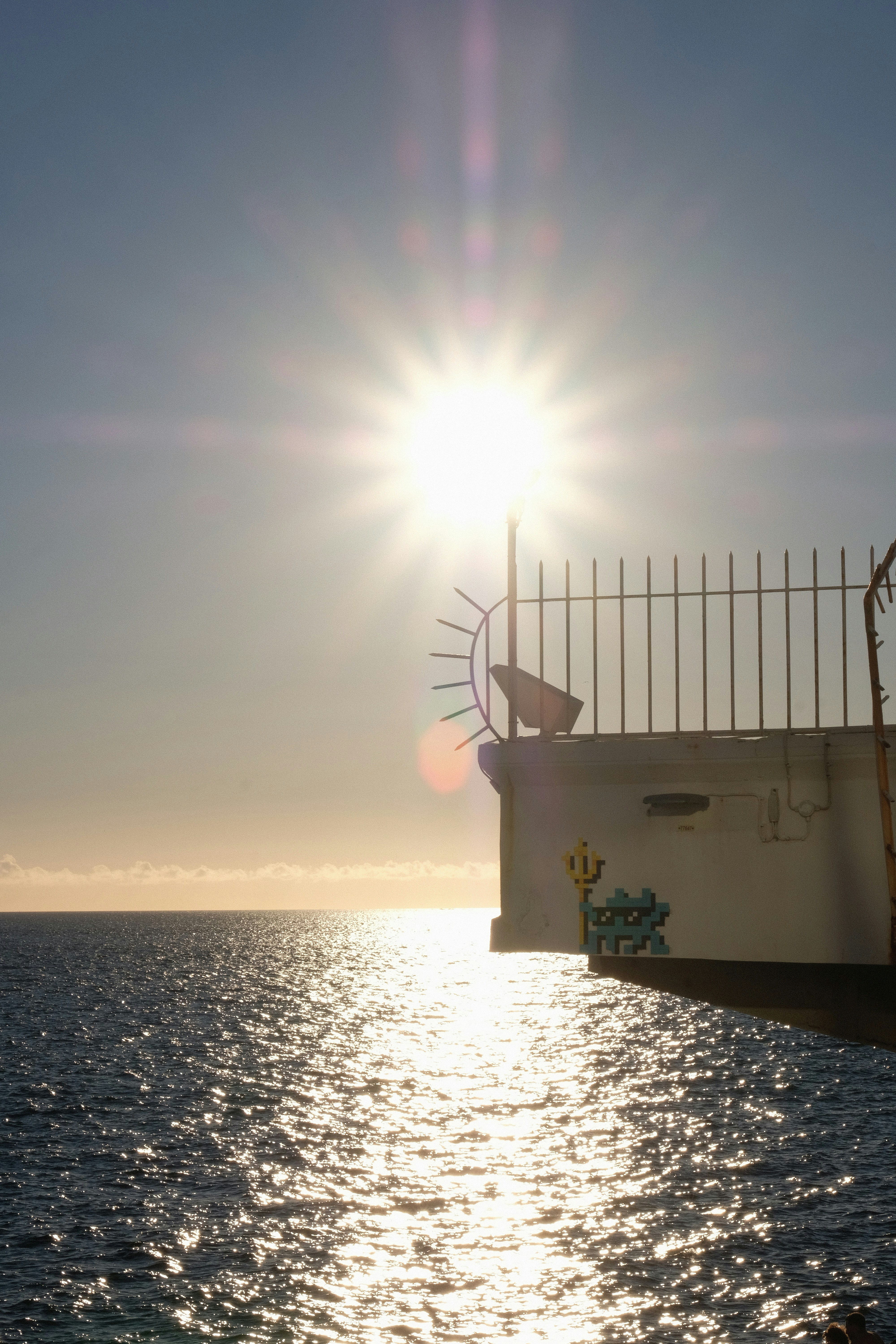 Sunburst Over the Rooftop Edge Facing a Glittering Sea