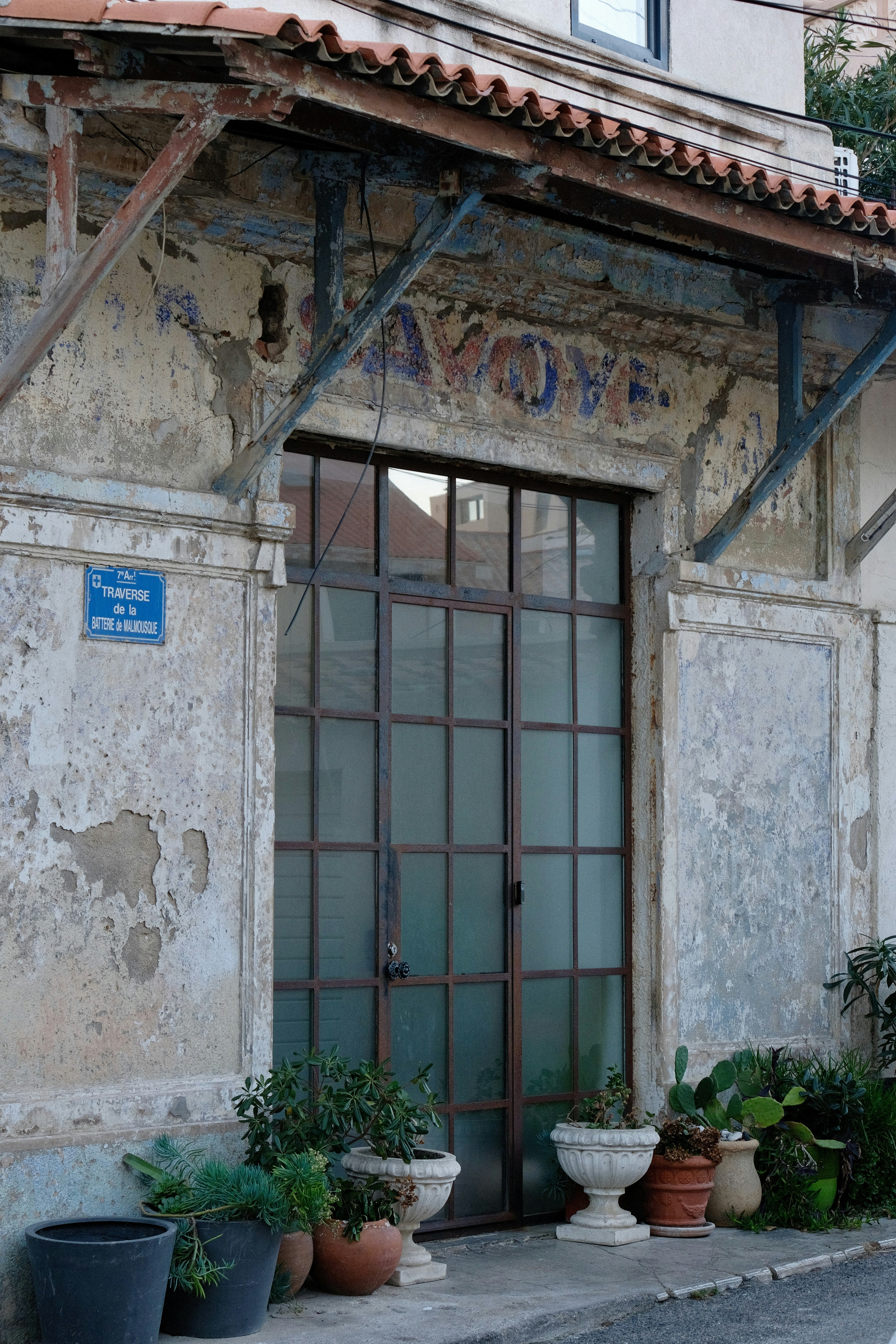 Weathered Gateway: A Quiet Entrance Framed by Time-Worn Walls and Potted Greens